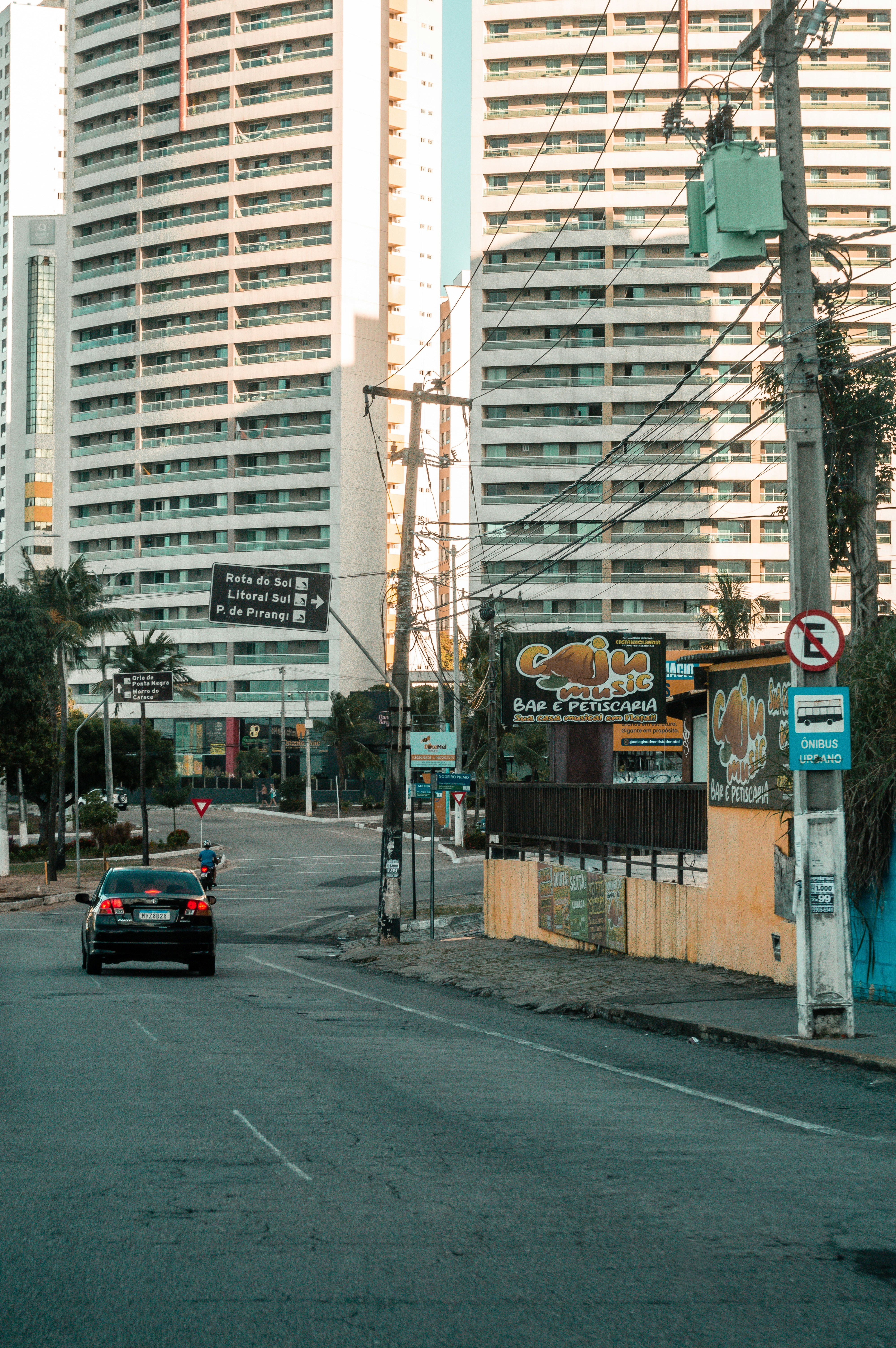 City Street Ascent: Cars, Signs, and Towers