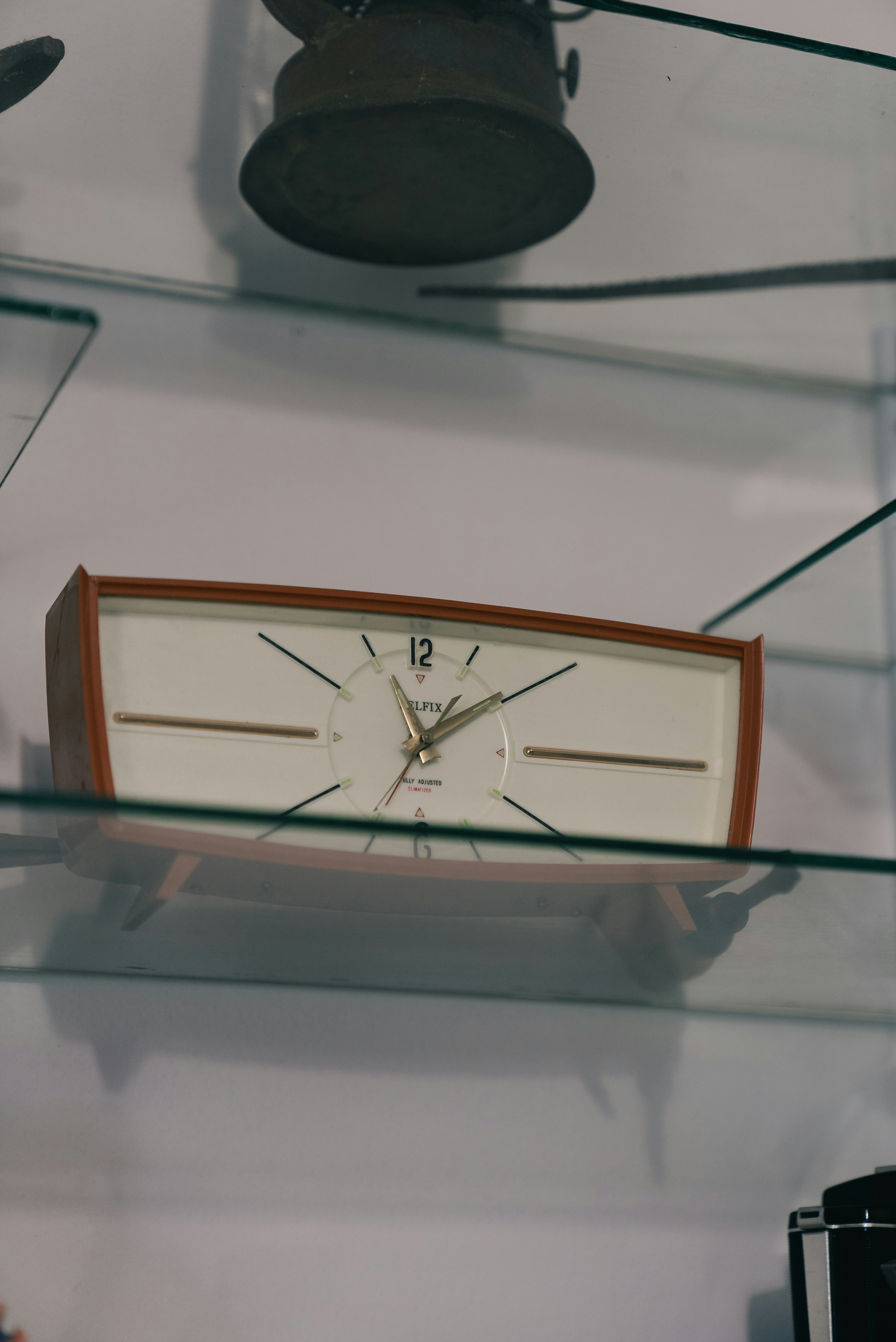 Retro Mantle: A Vintage Clock Shelves a Glass-Top Reflection