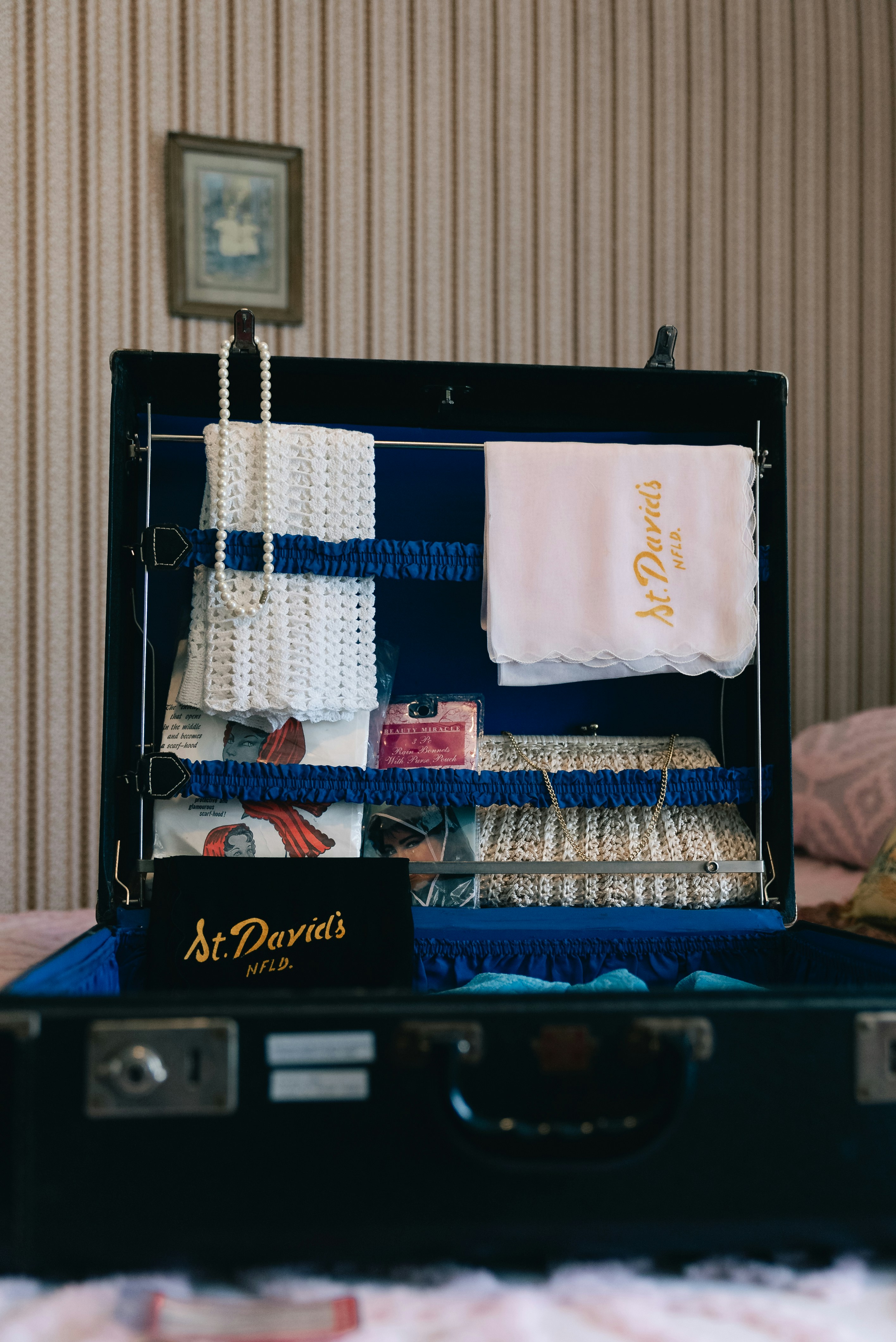 A Couture Suitcase: Stowed Garments and Silk Ties in a Velvet Case
