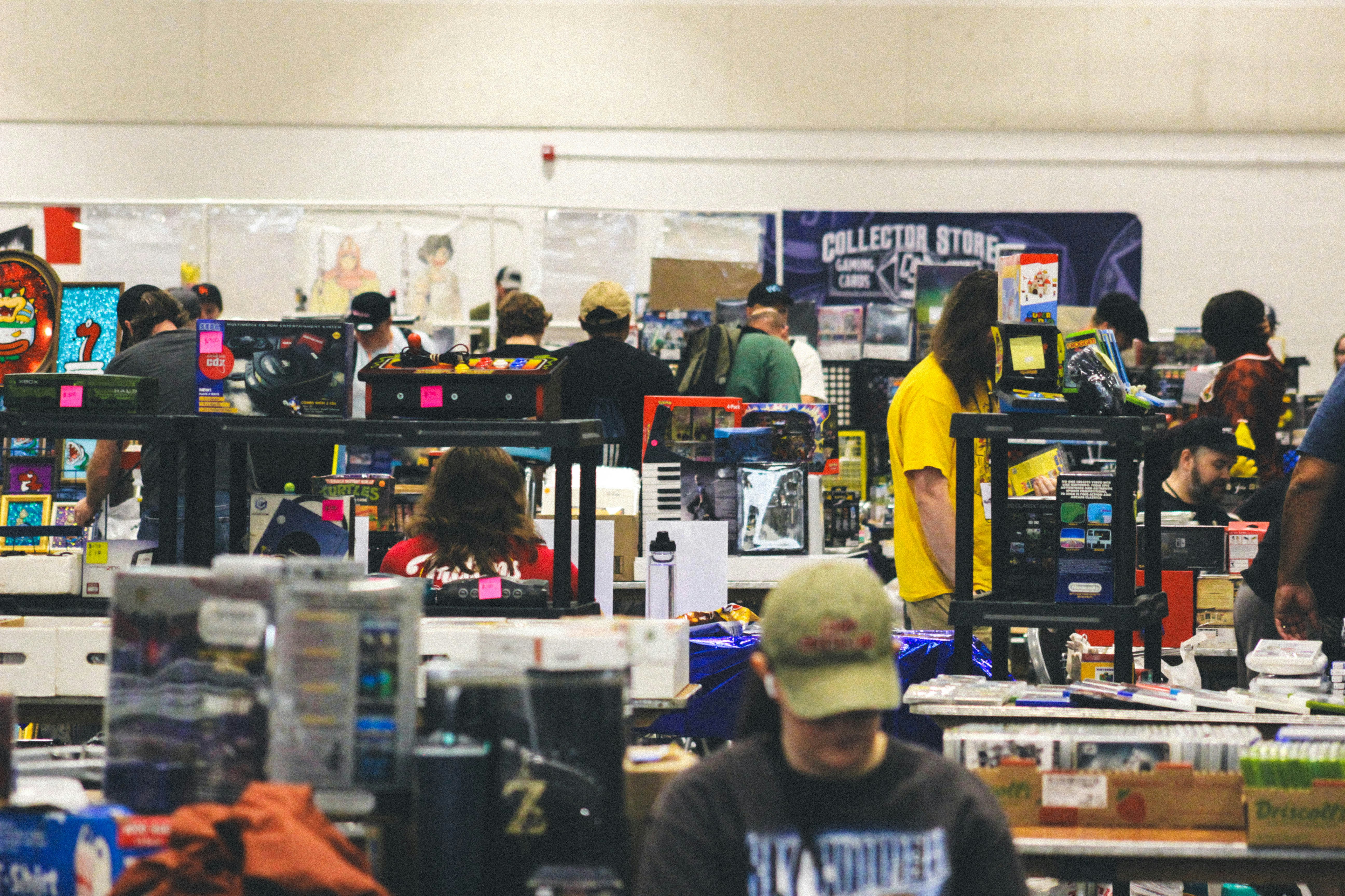 Crowded Treasure Trove: A Comic and Gadget Exchange in a Bustling Convention Hall