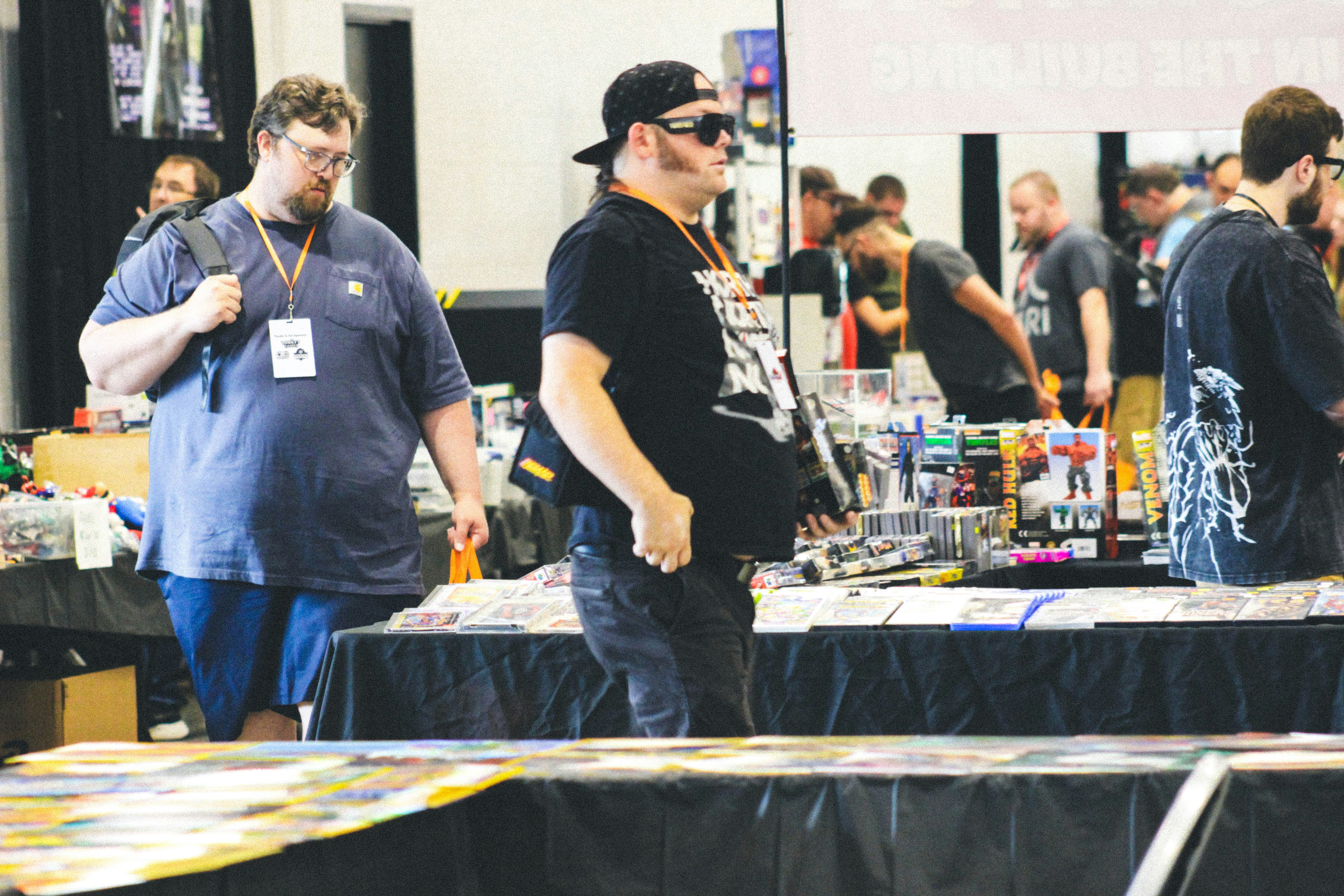 Lively convention aisle: attendees browse a toy and comic items at a busy booth