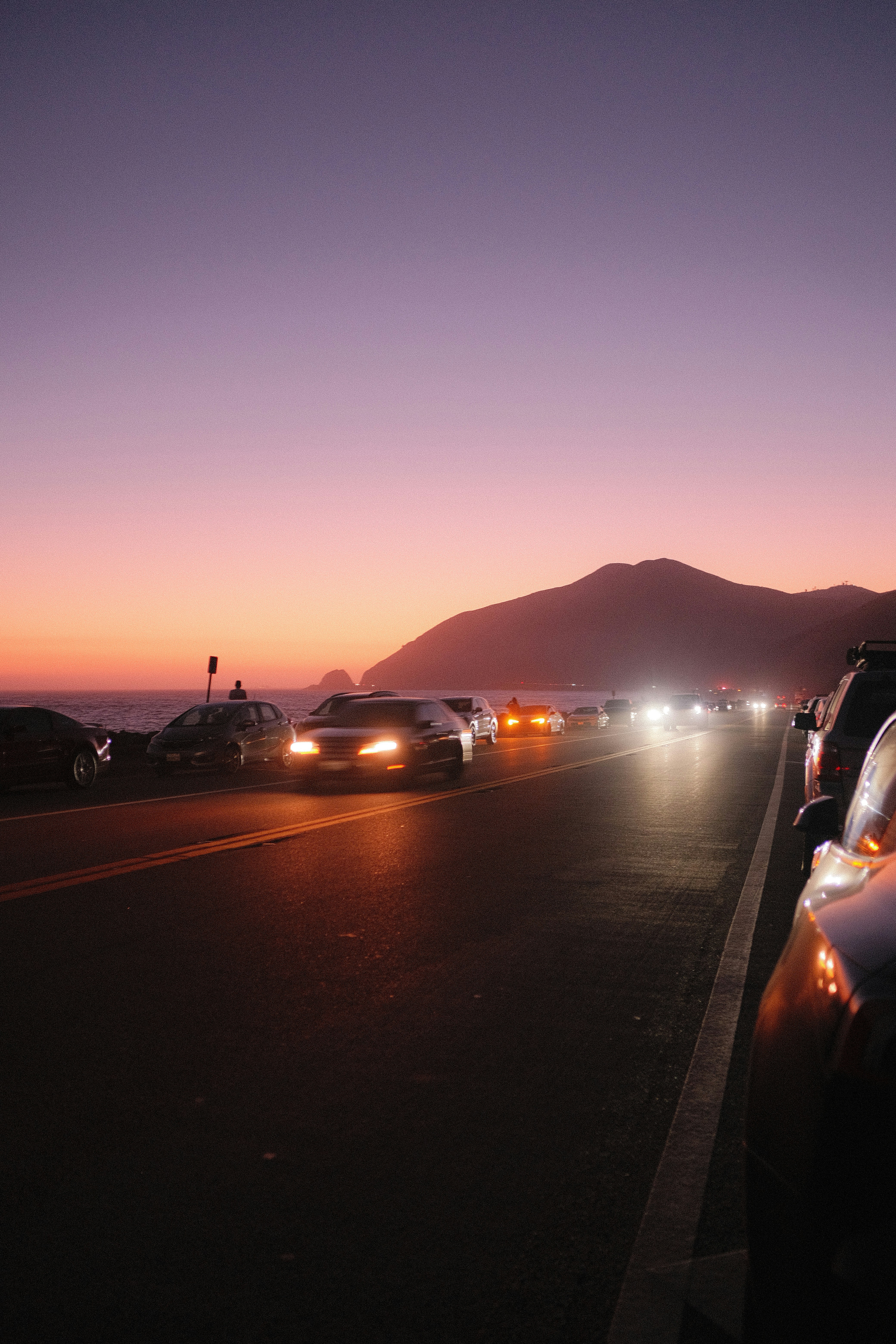 Sunset Highway: Cars Streaking Past a Mountain Vista