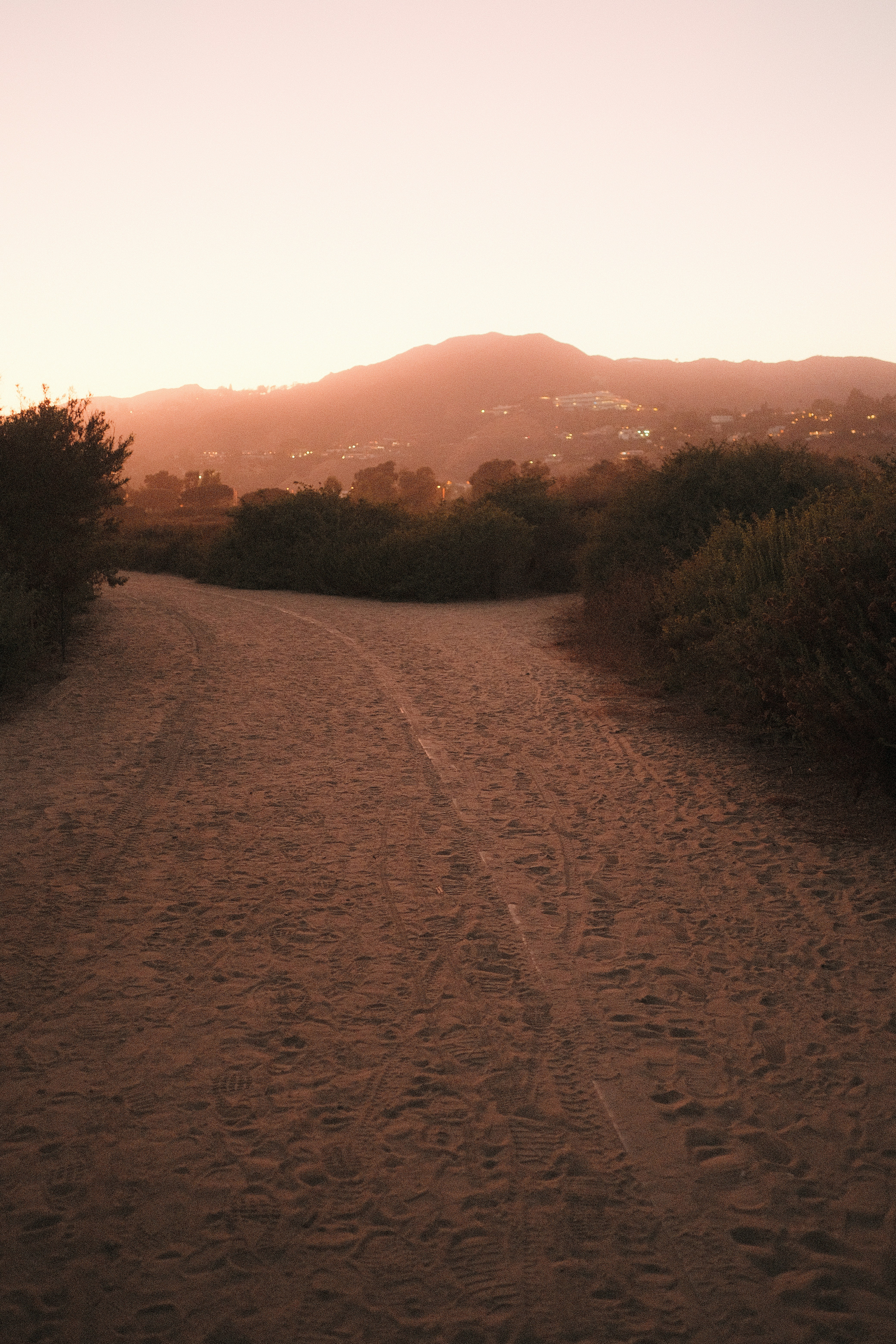 Dusty Path at Sunset: A Quiet Descent Toward the Distant Hills