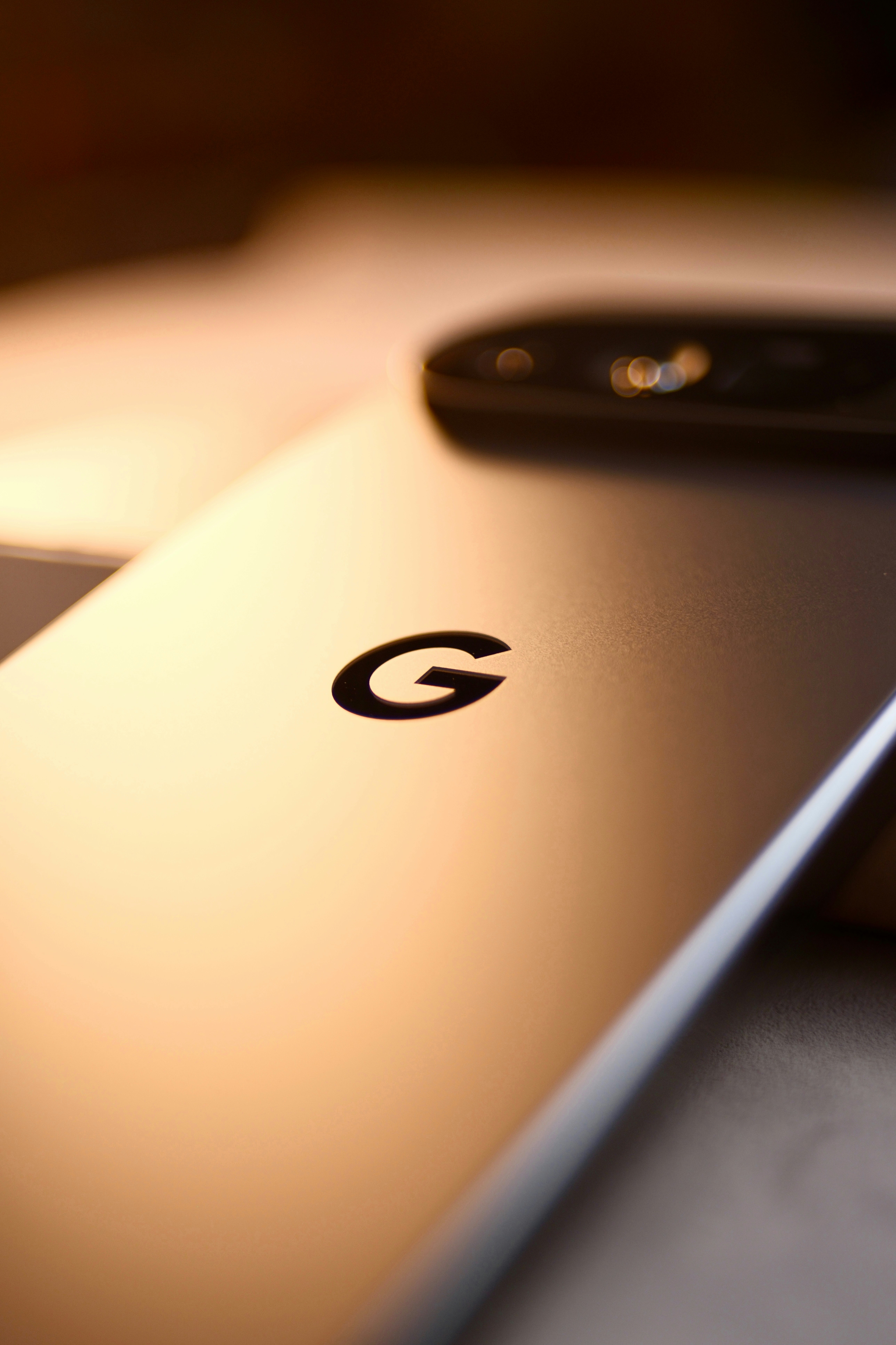 Gentle G: Close-up of a metallic device emblem in warm light