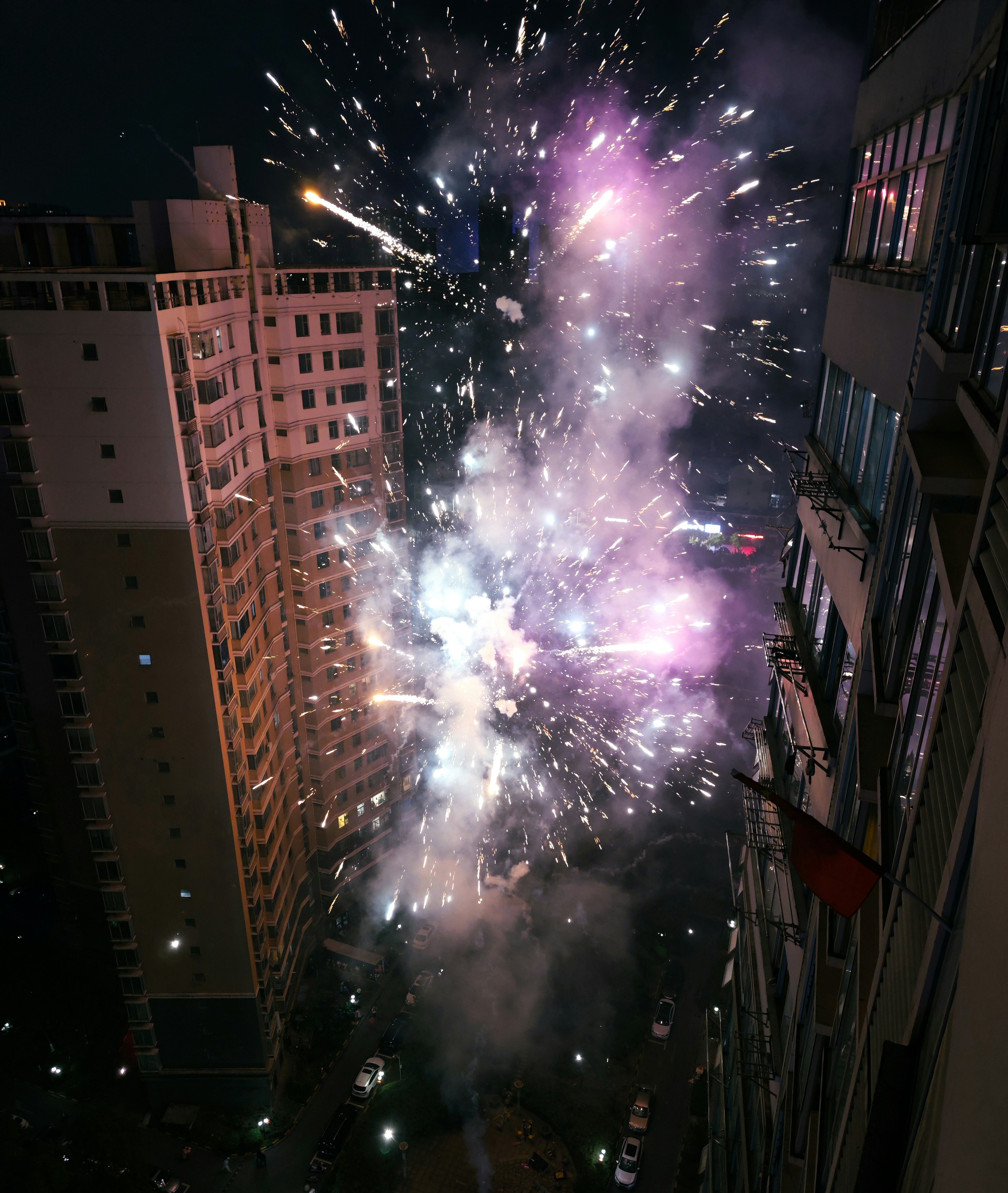 Skyfall Over the City: Fireworks Drench a Narrow Street