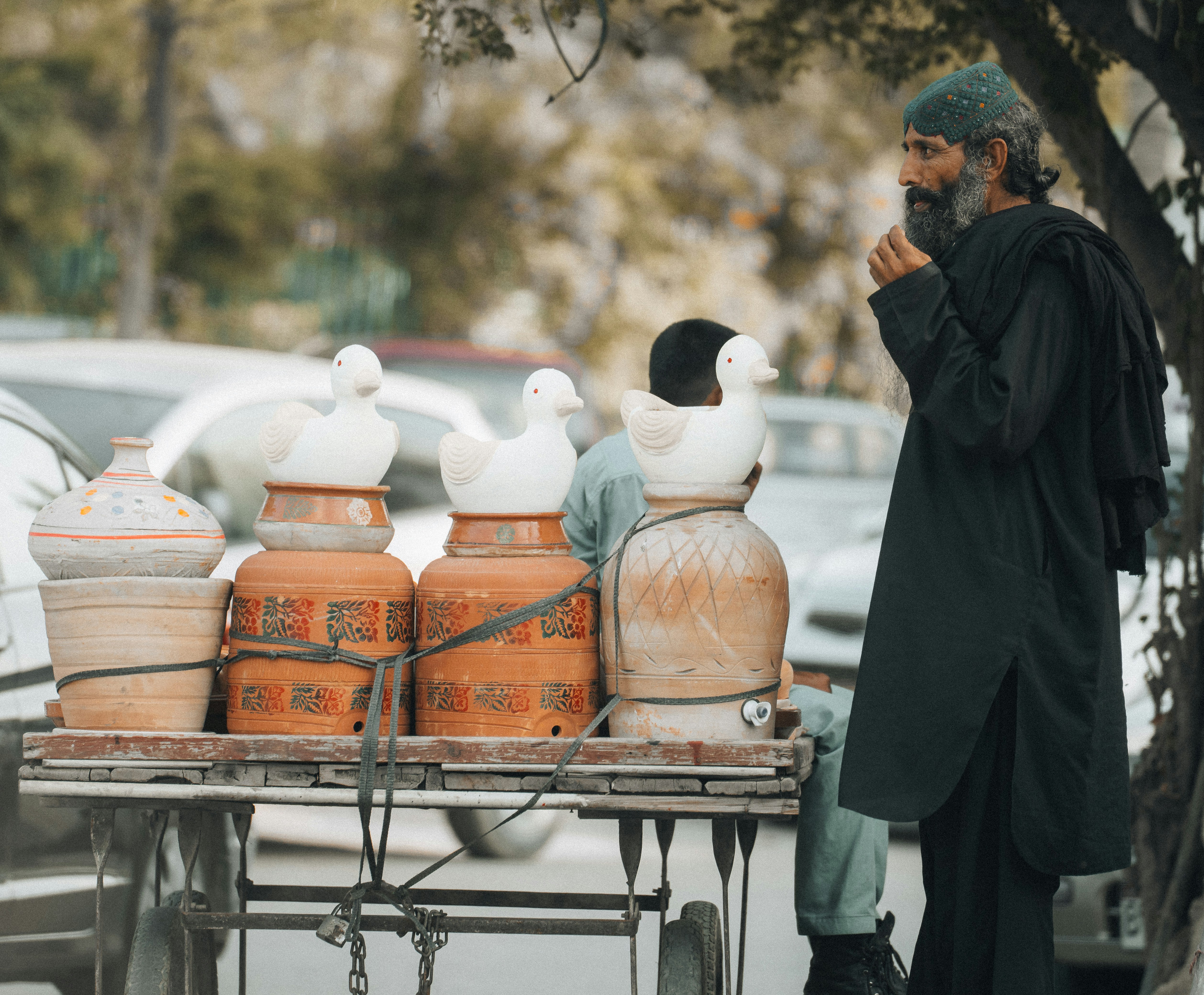 Street Vendor and Ceramic Duck Jars: A Quiet Moment on a Curbside Cart