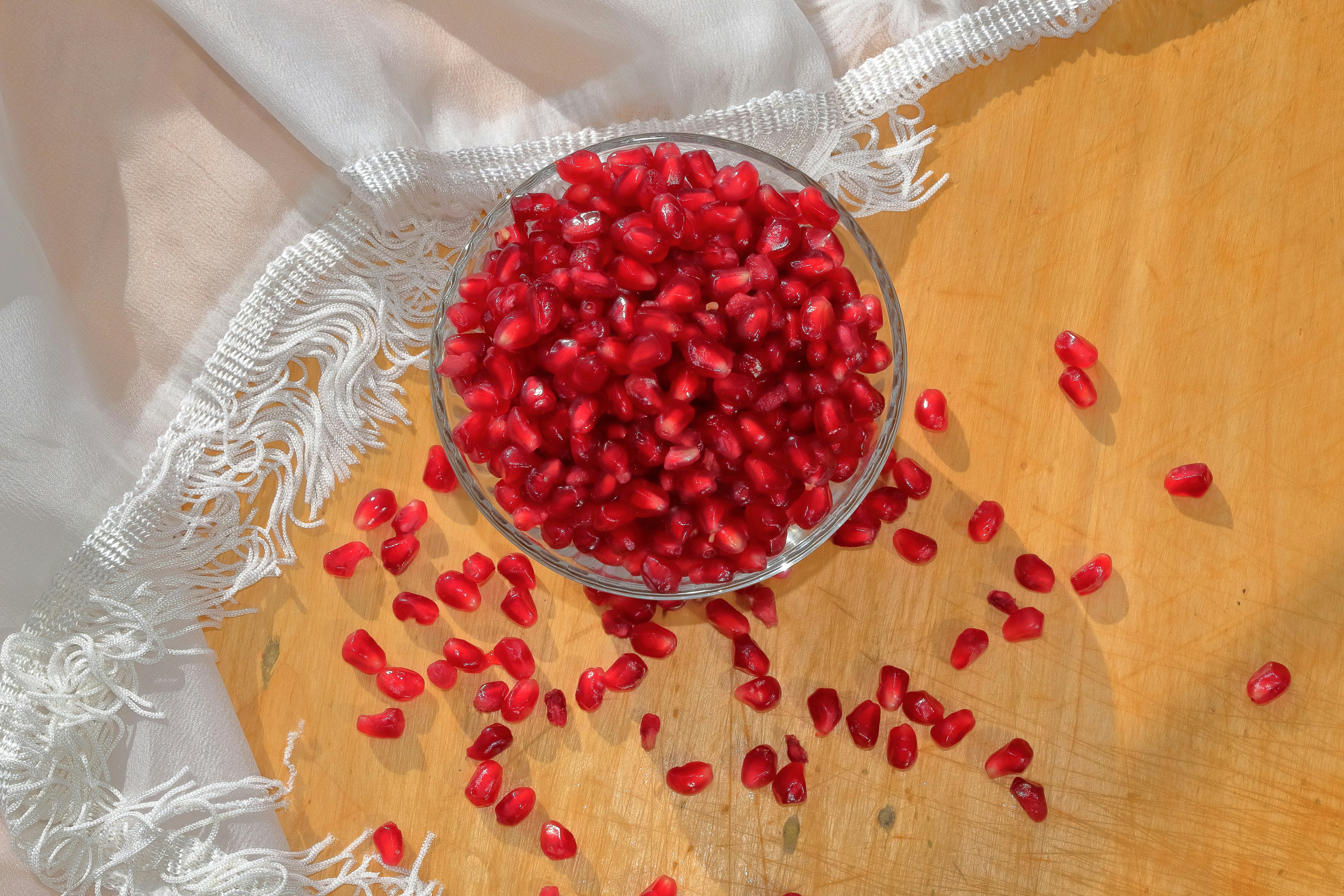 Crimson Heart: Pomegranate Seeds spill across a sunlit wooden table