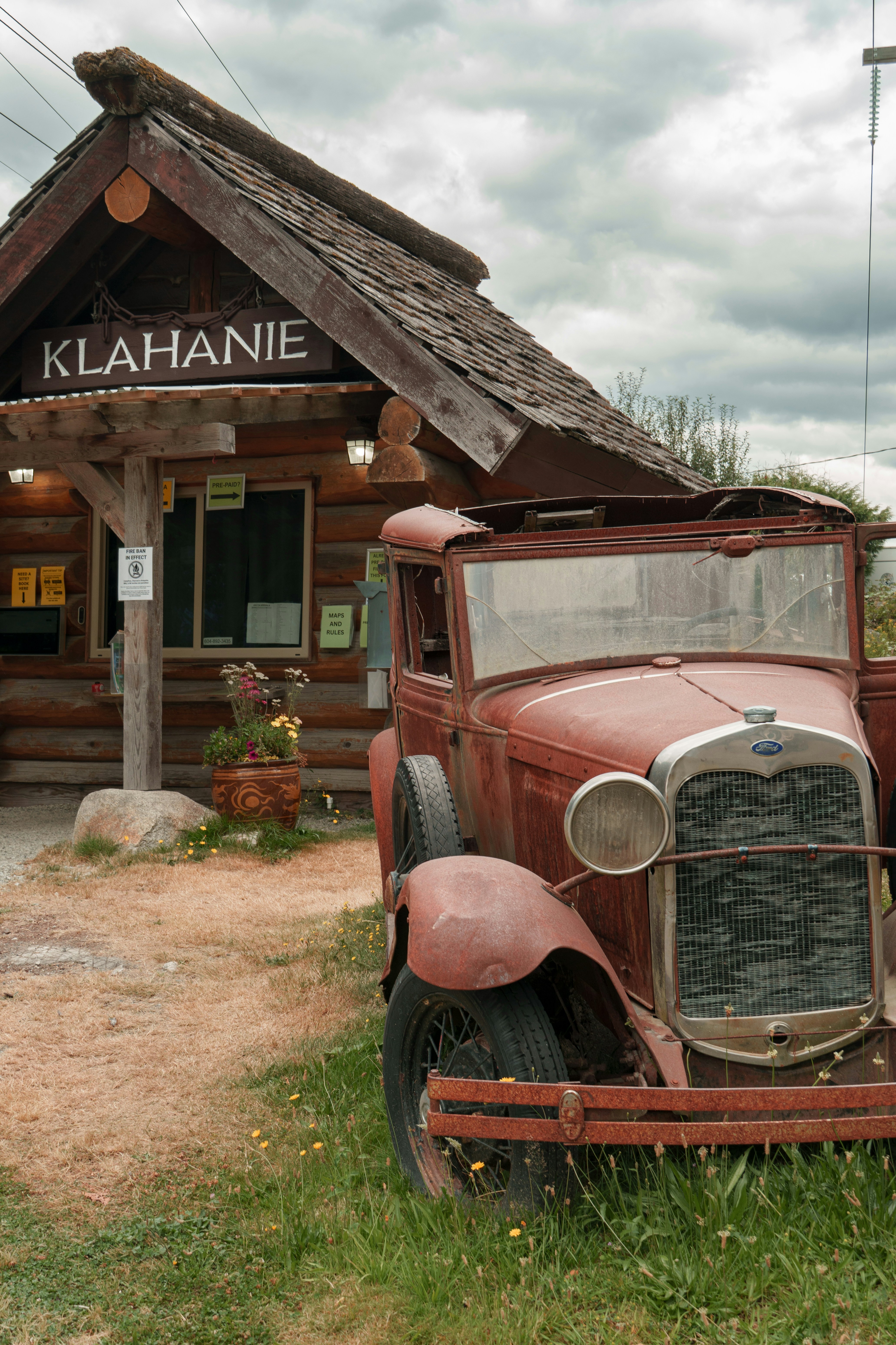 Rusty Nostalgia: A Retro Truck Guarding a Log Cabin