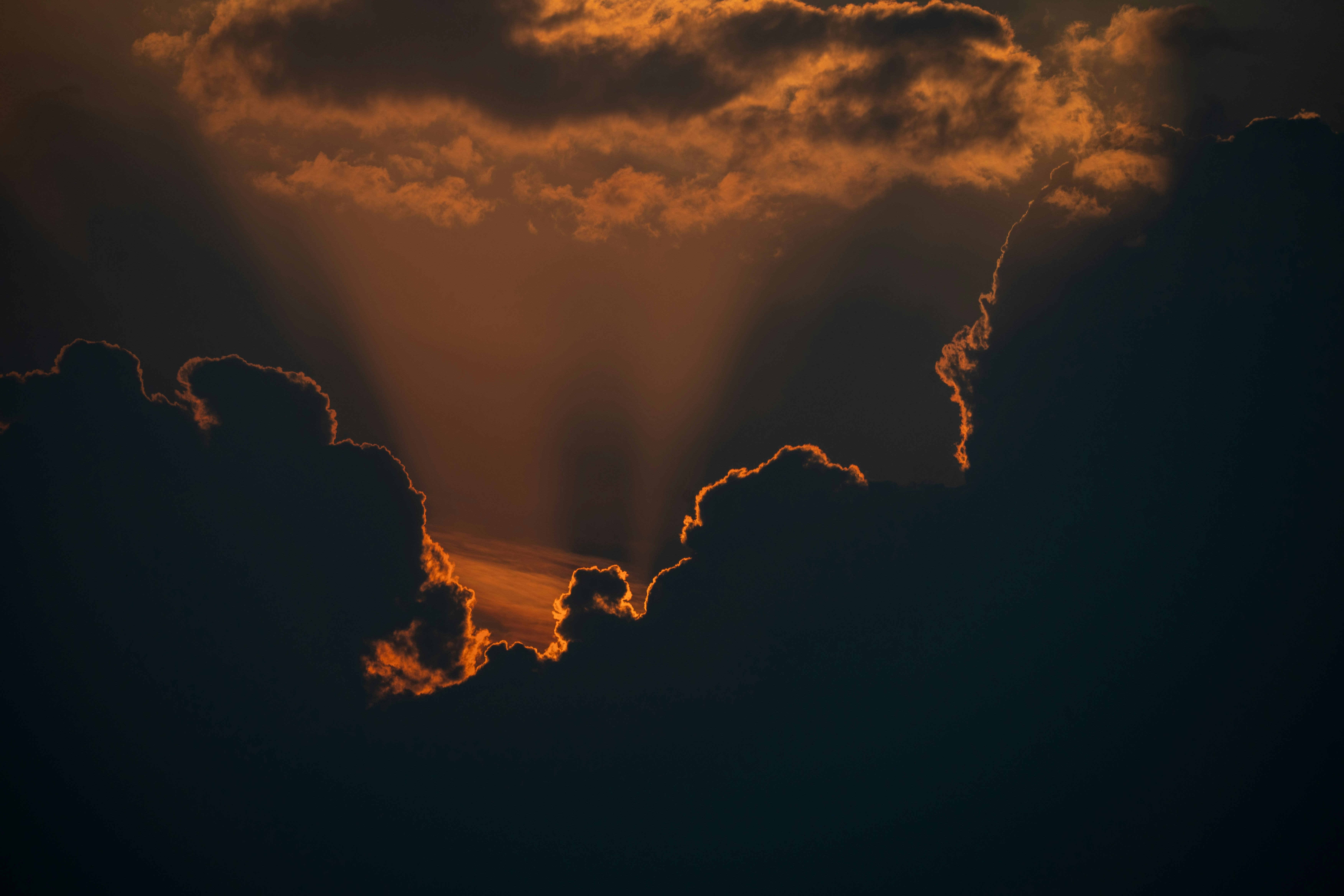 Rays of Dawn Piercing a Distant Cloud Barrier