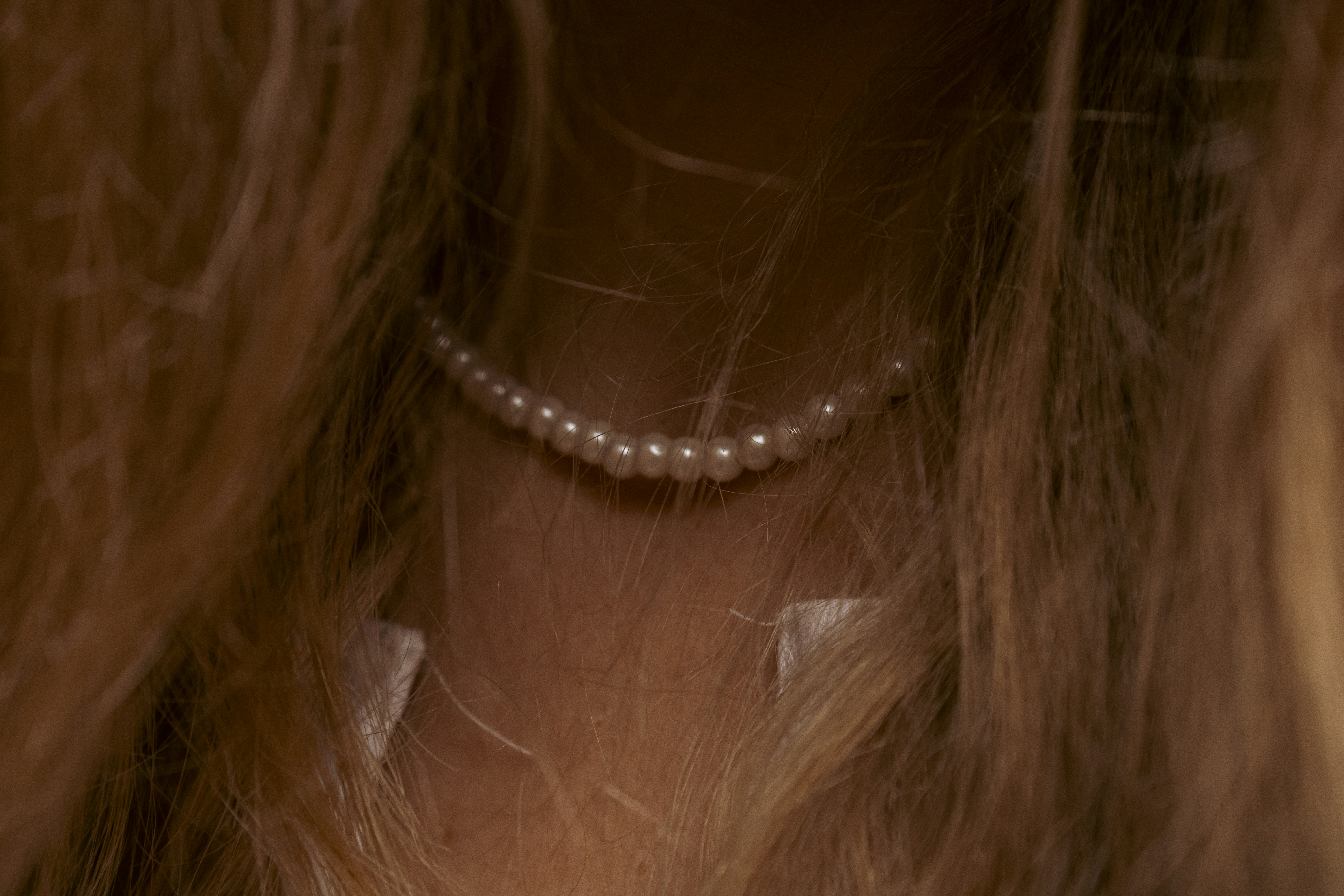 Pearls at the Edge: A Whisper of Neckline and Hair