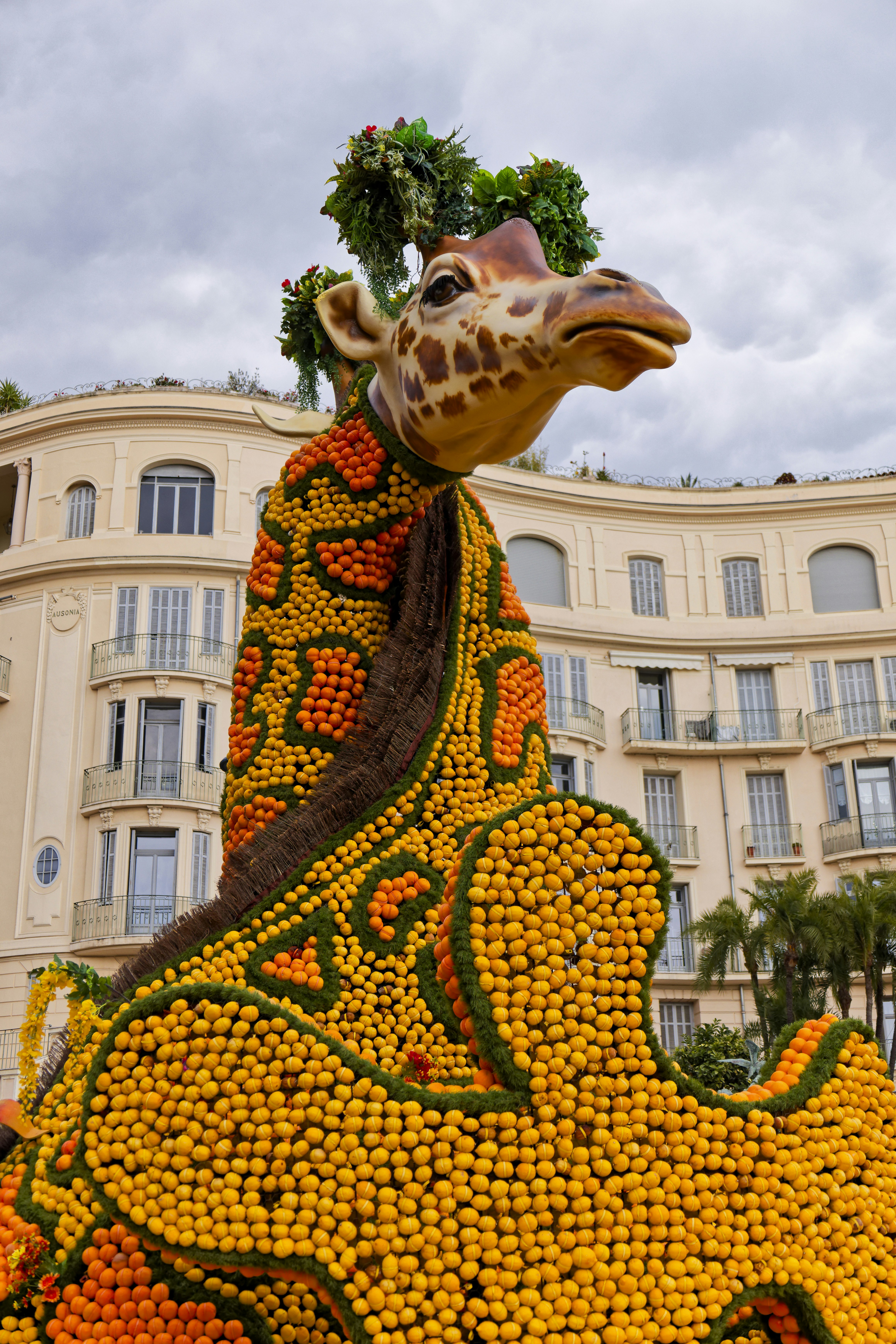 Amber Mosaic Giraffe: a sculpture of citrus-colored scales climbs toward the sky