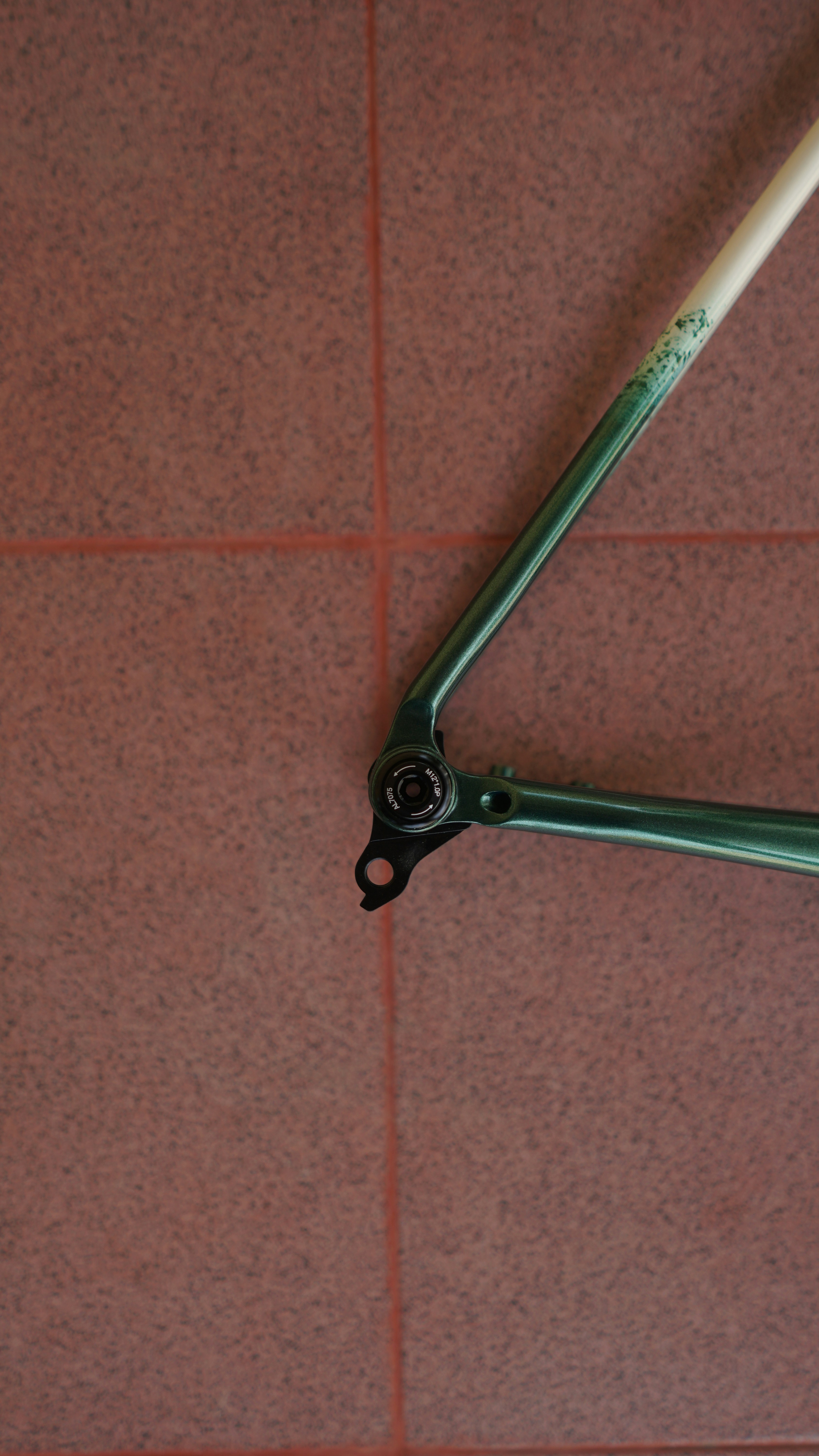 Partial Bicycle Crankset Resting on Red Tile Floor