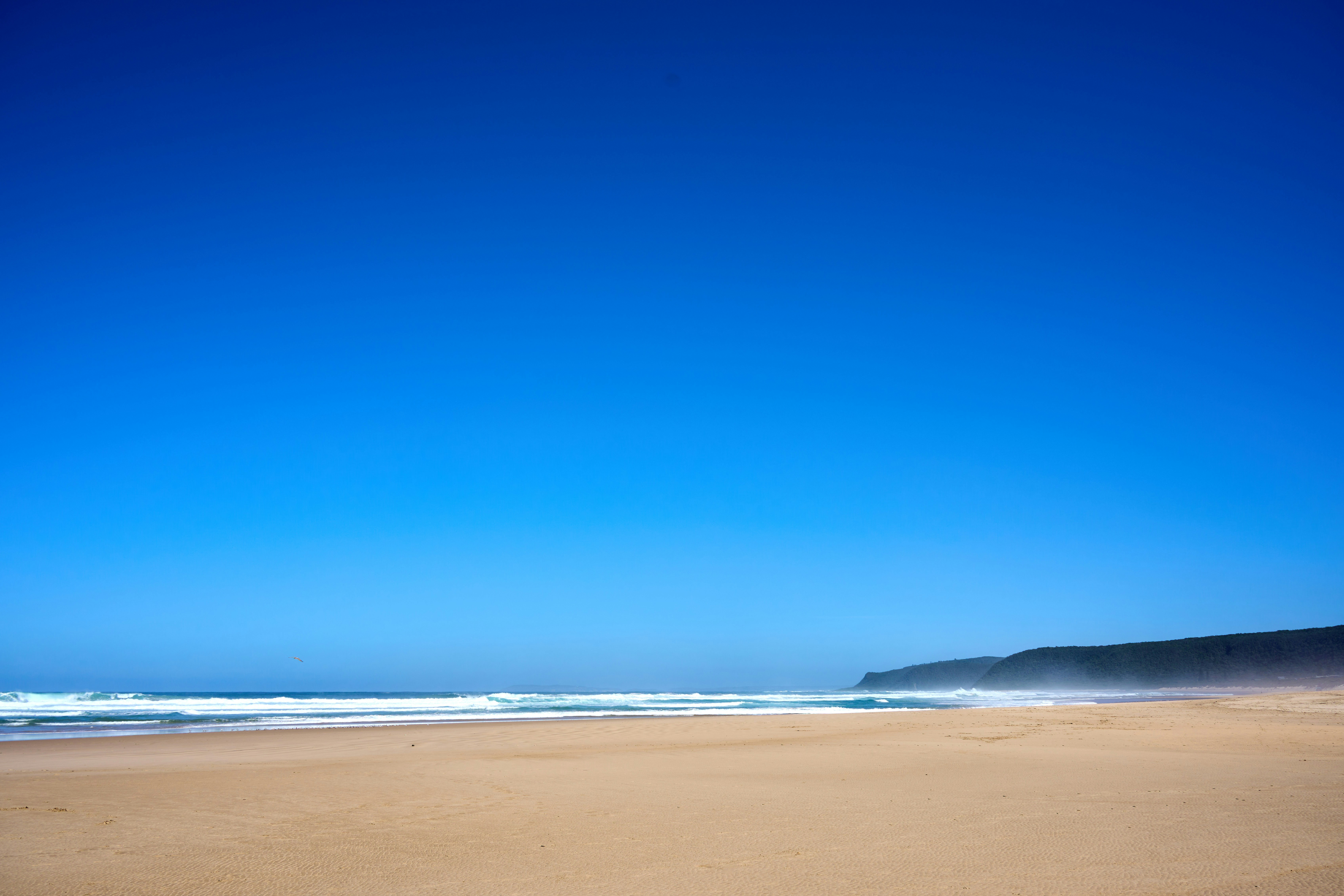 Horizon of Quiet Blue: A Bare Beach Under an Expansive Sky