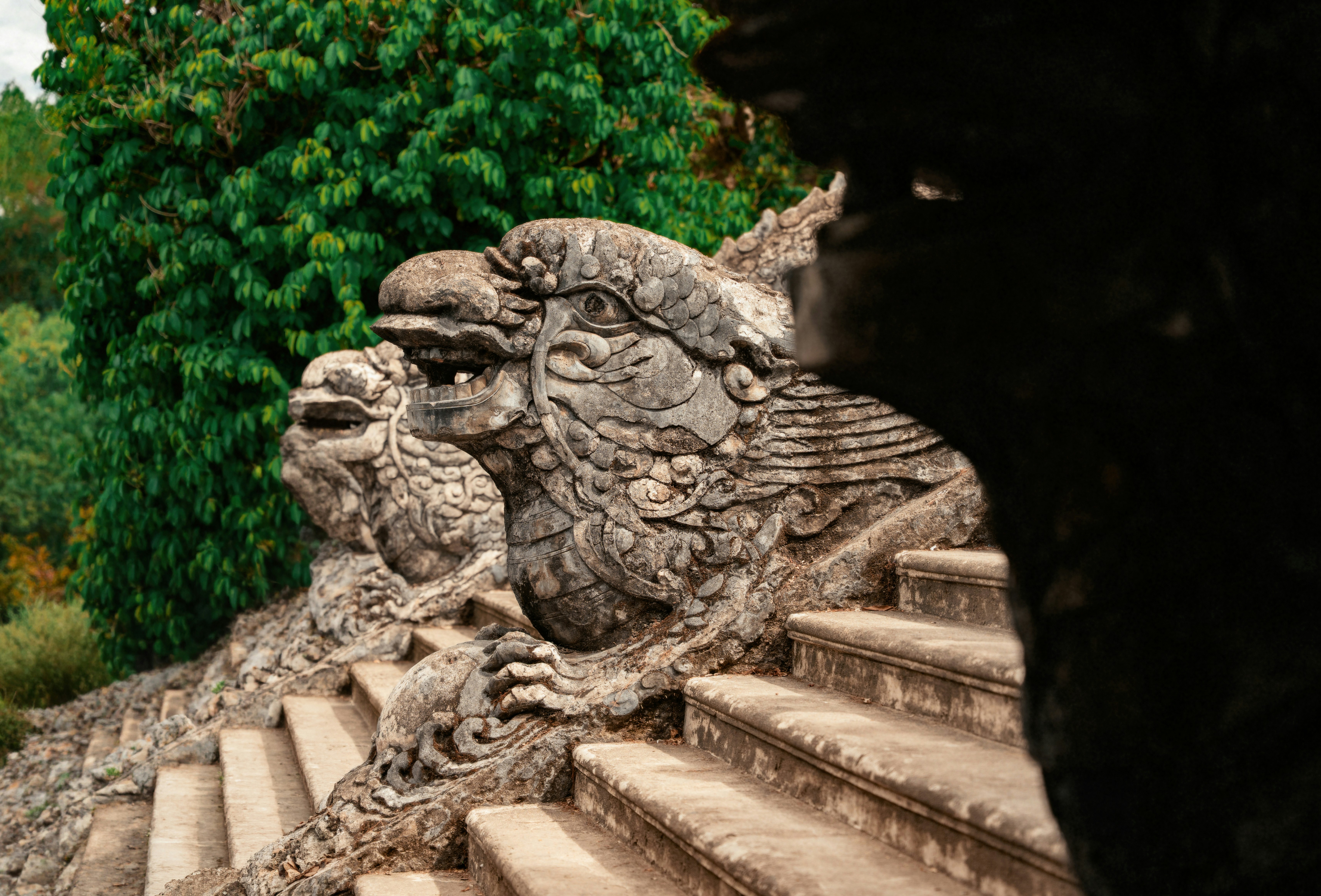 Stone Guardian on the Steps: A Dragon Figurine Emerges from the Garden