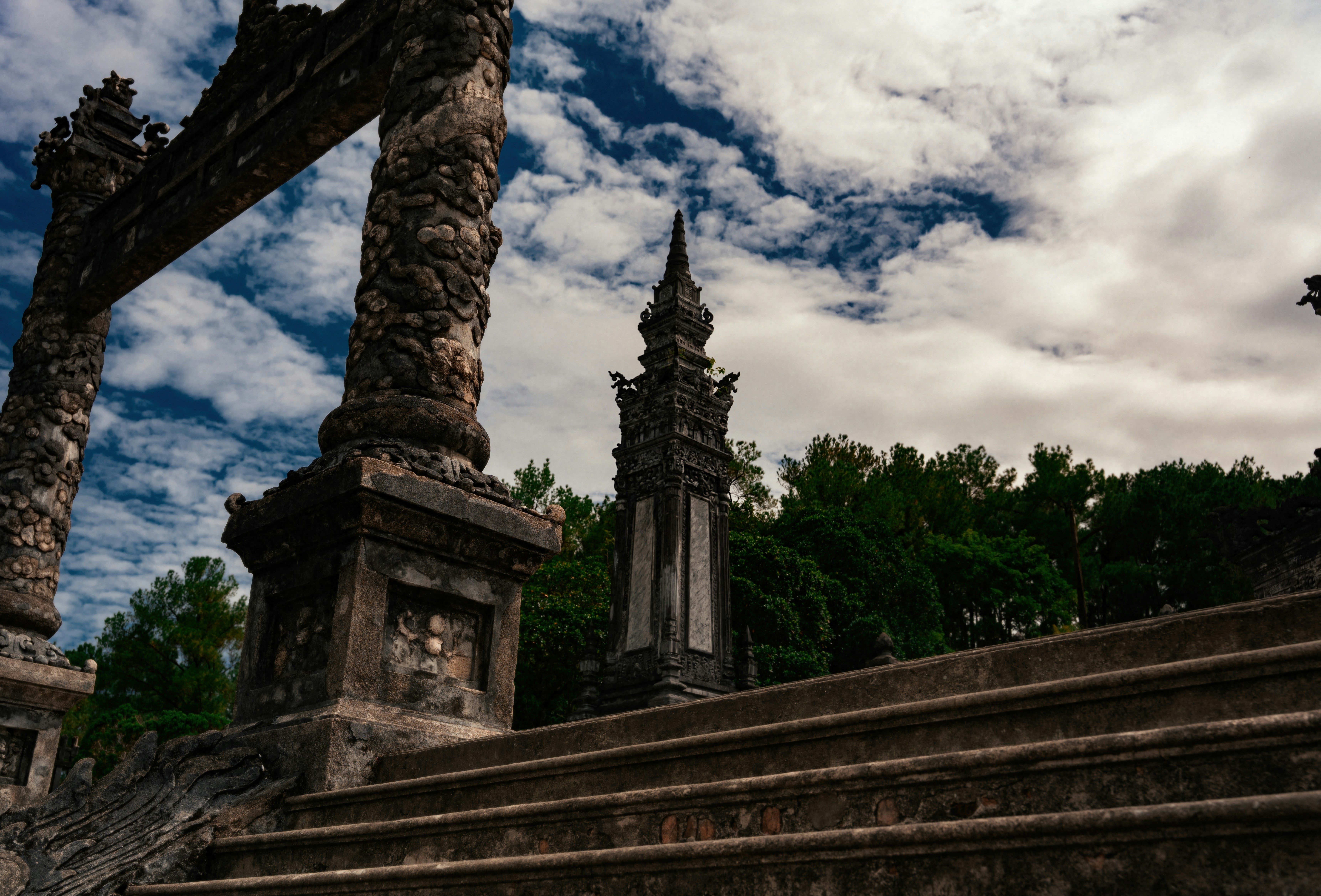 Stone Carvings Ascend the Sky: A Temple Stairway Under a Clouded Sky