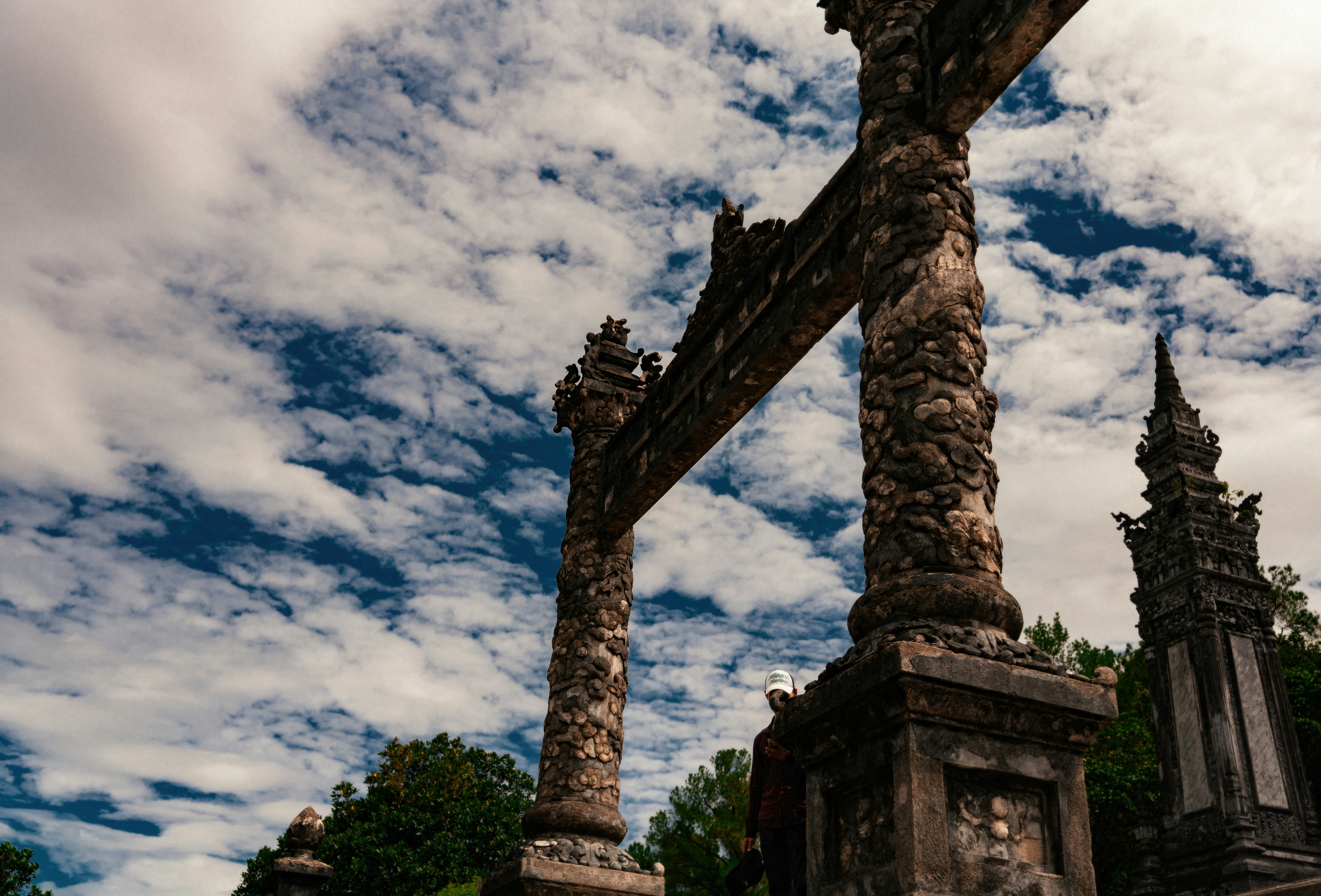 Ancient Stone Gateway Reaches Toward a Sky-Blue Canopy
