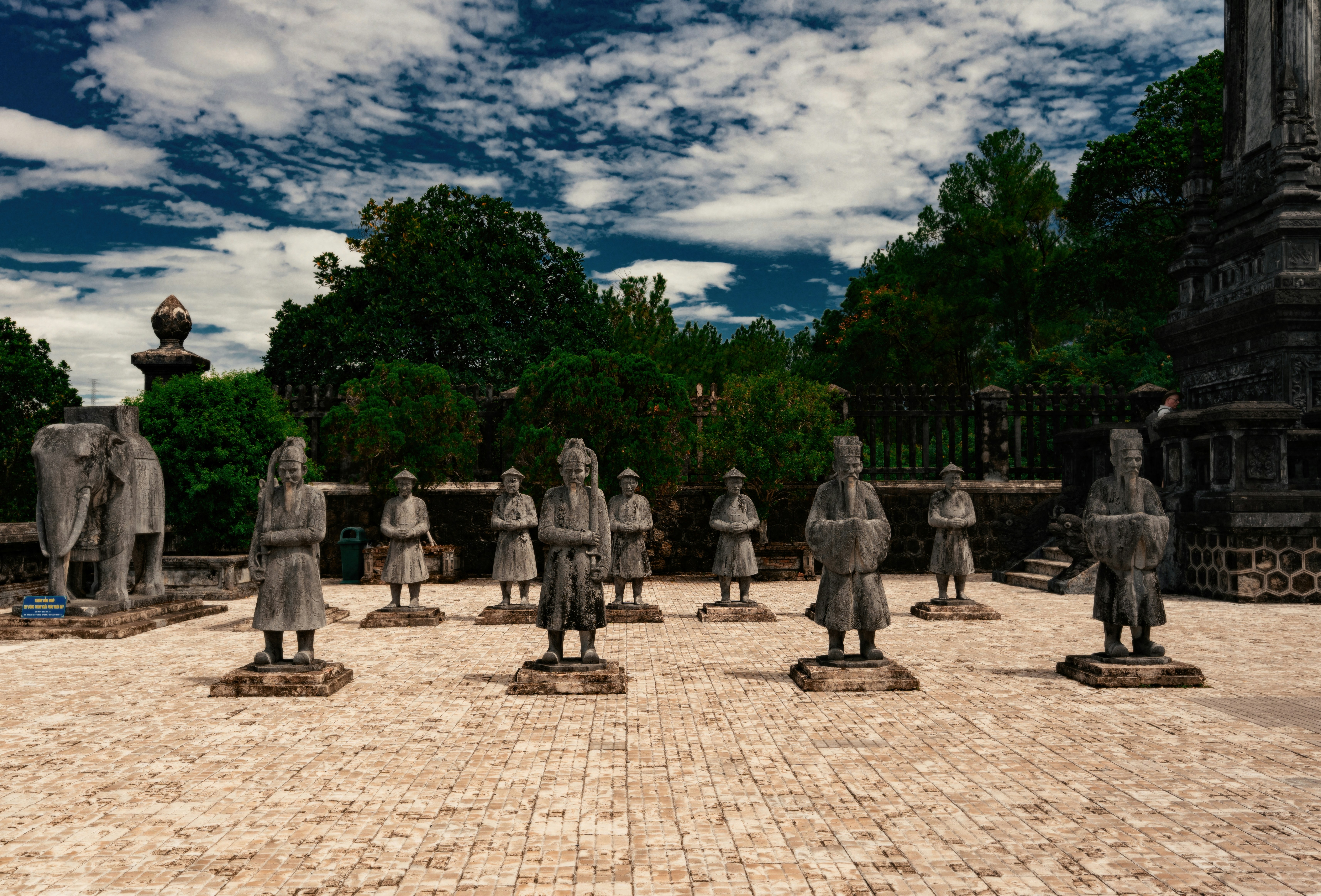 Row of Stone Statues Guarding a Sunlit Courtyard