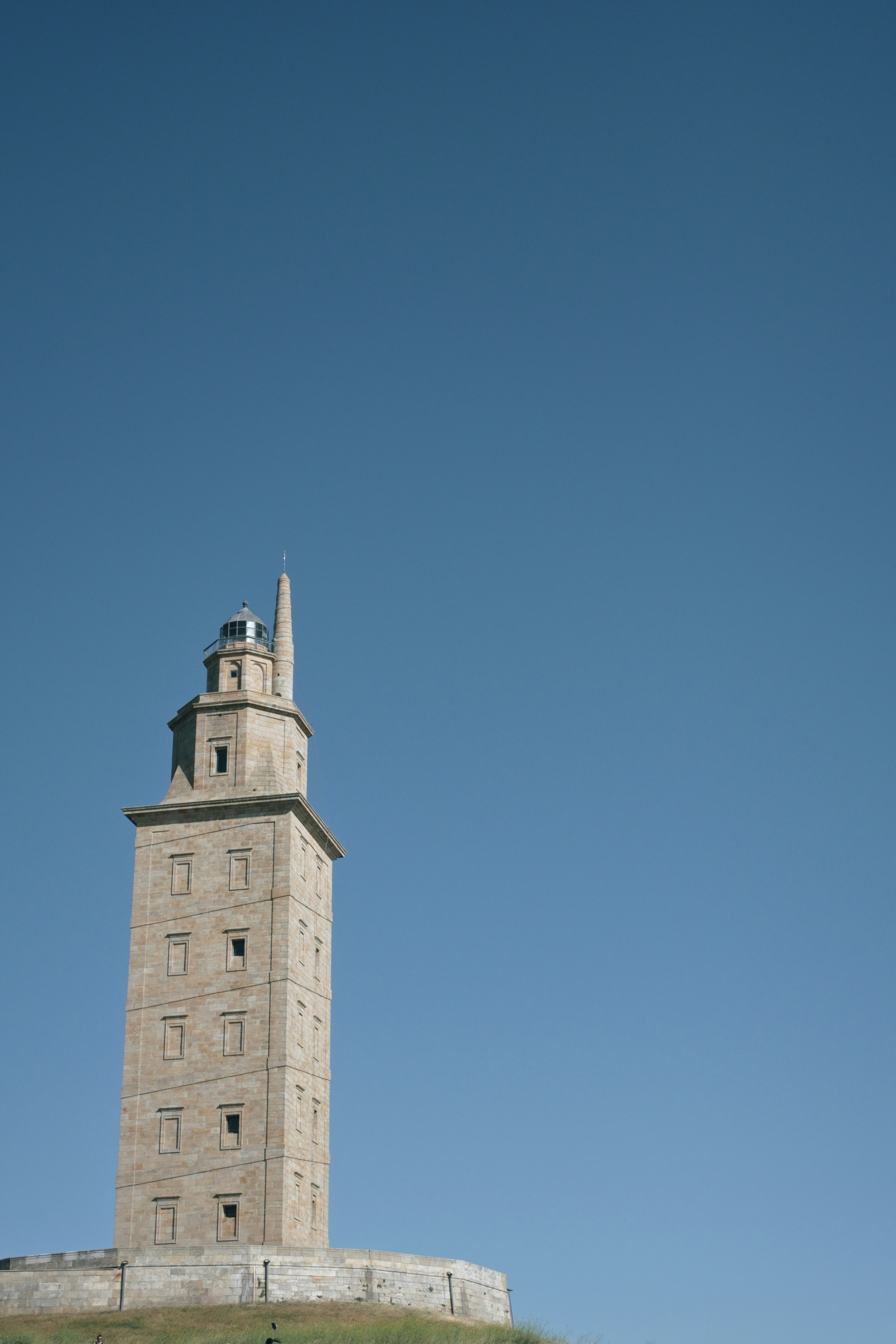 Lone lighthouse rising against a vast blue sky