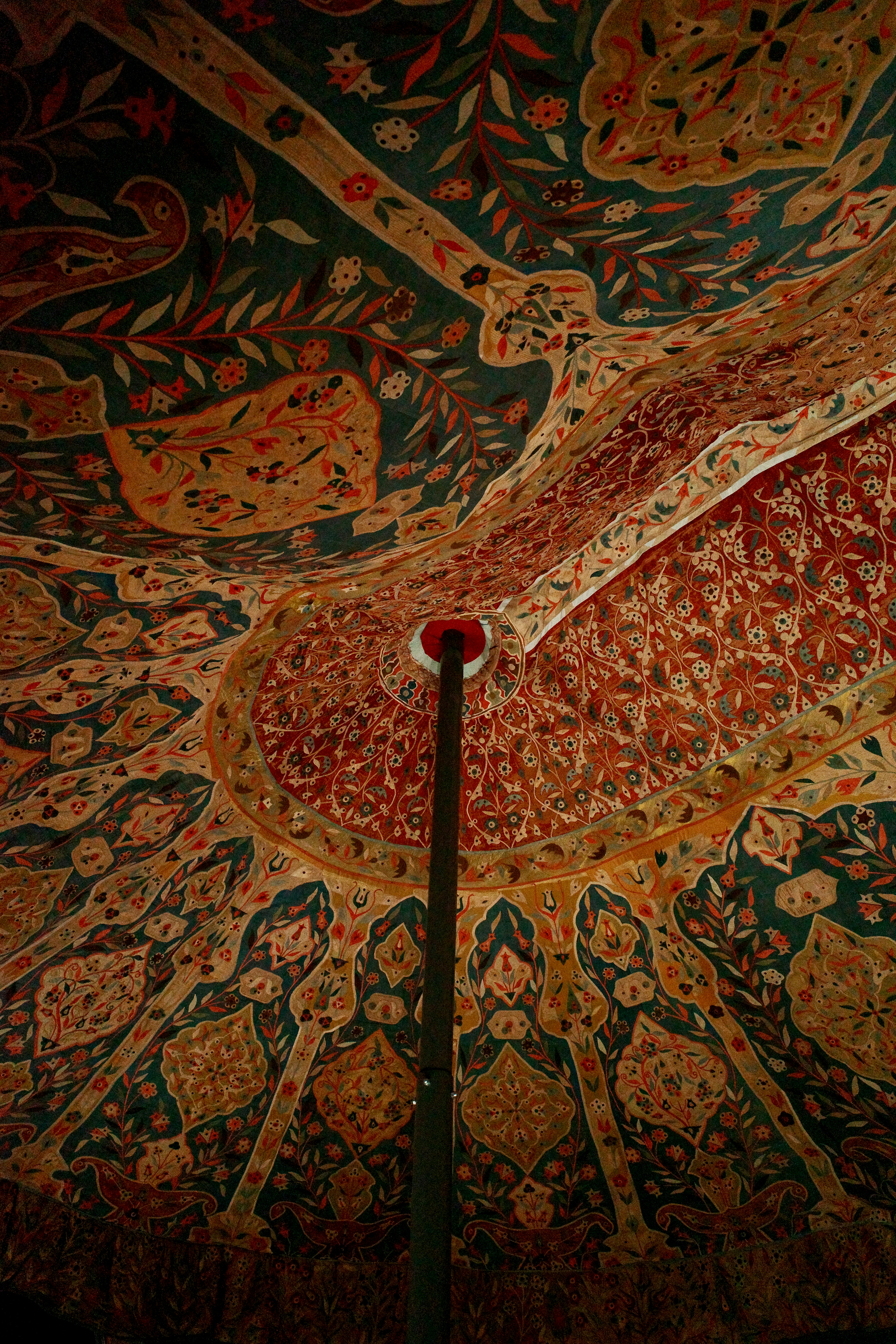 Domed ceiling of a richly painted interior converging on a central support