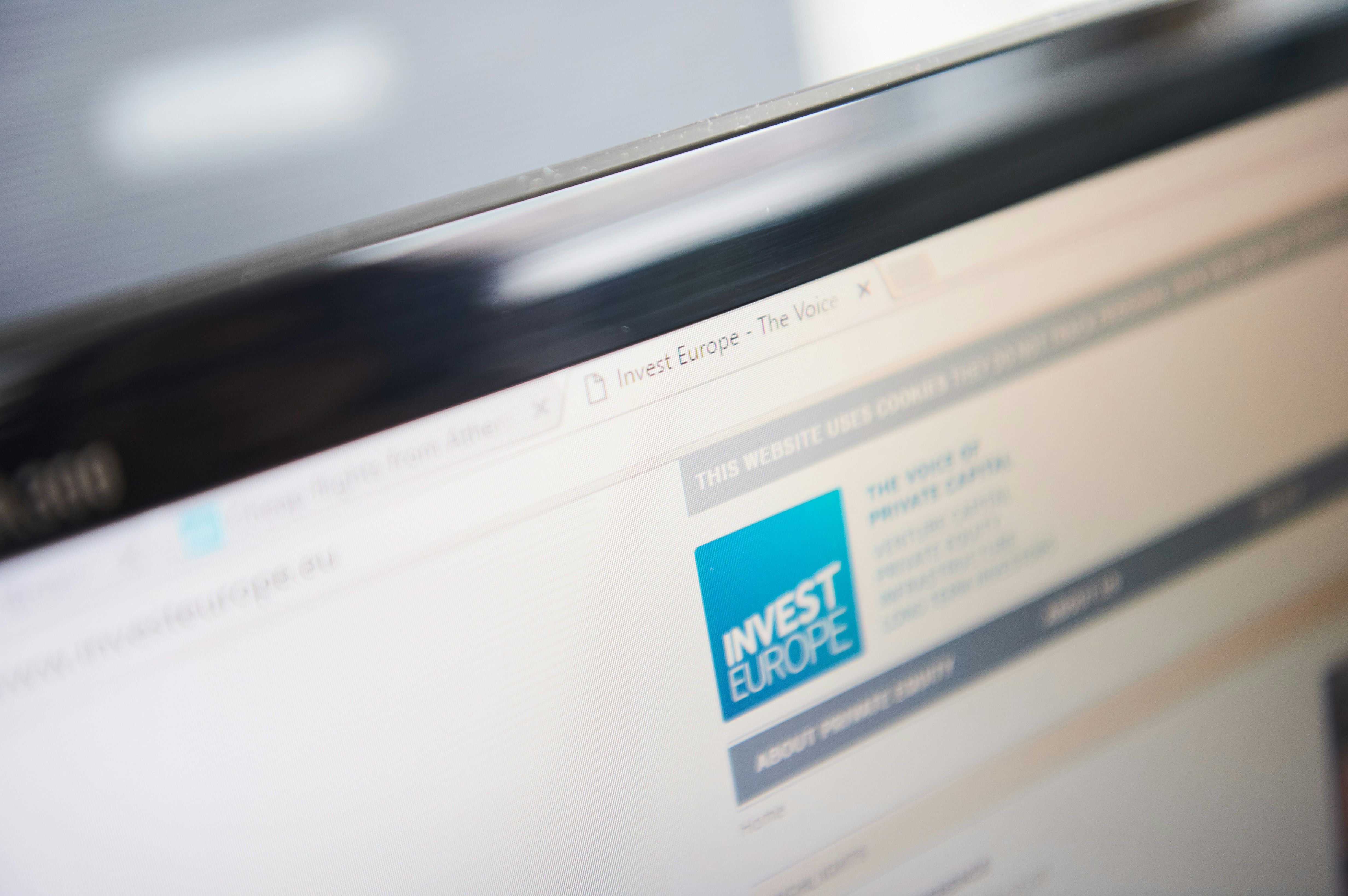 Blurry Laptop Screen with Invest Europe Logo on a Desk