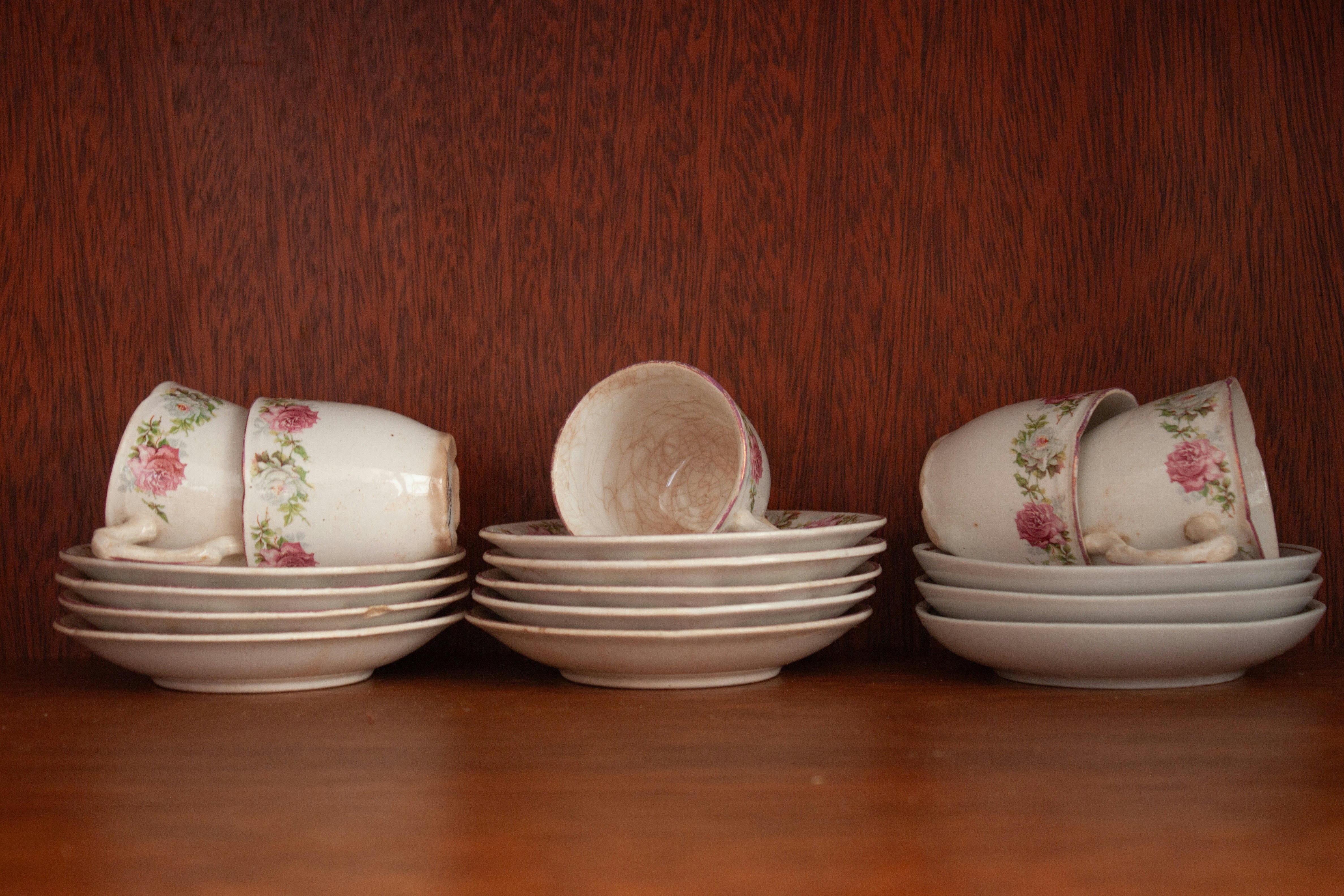 Three Ceramic Stacks: Floral Teacups Resting on a Wooden Shelf