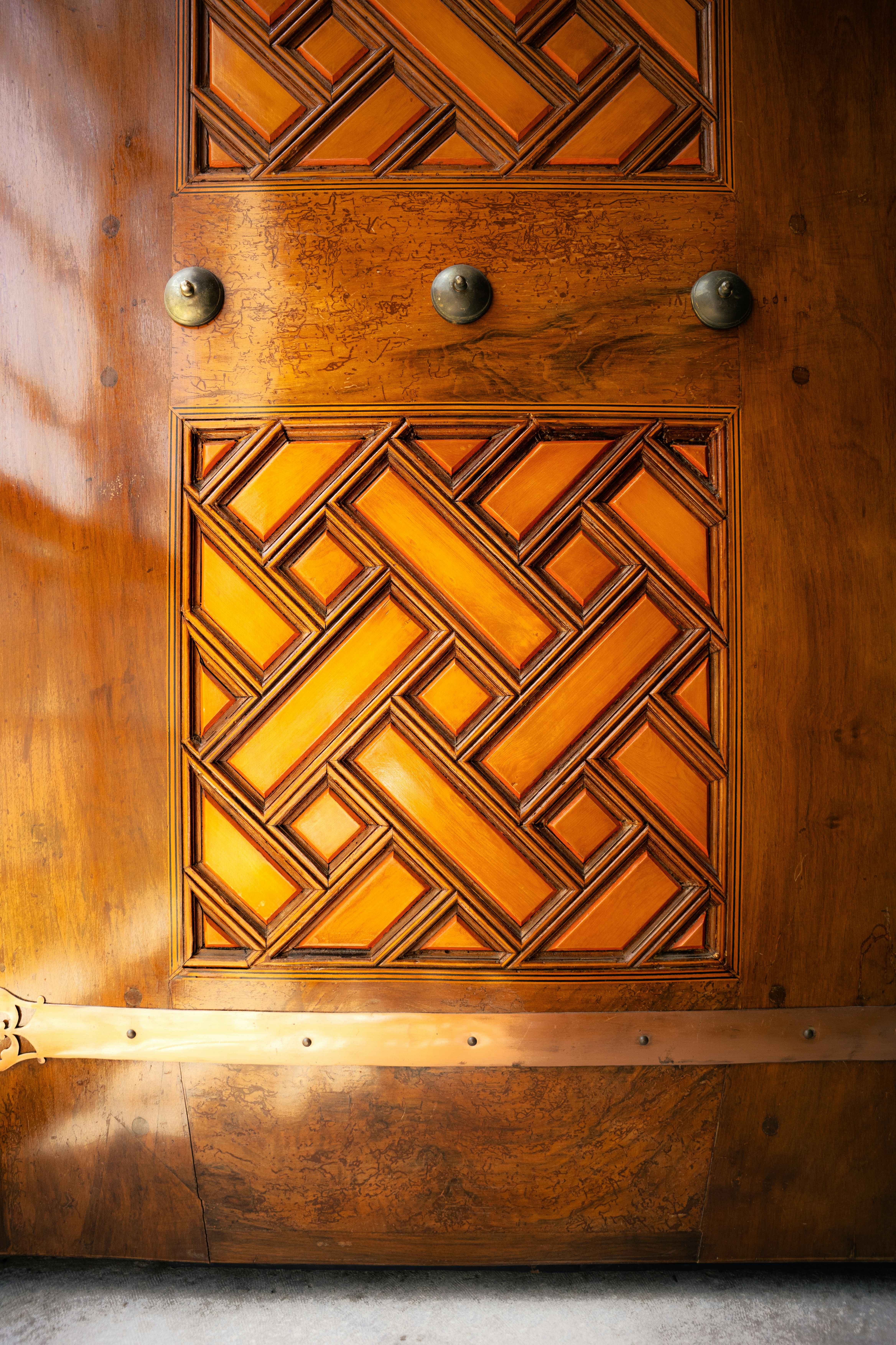 Geometric Timber: Carved Panels on a Warm Wooden Door
