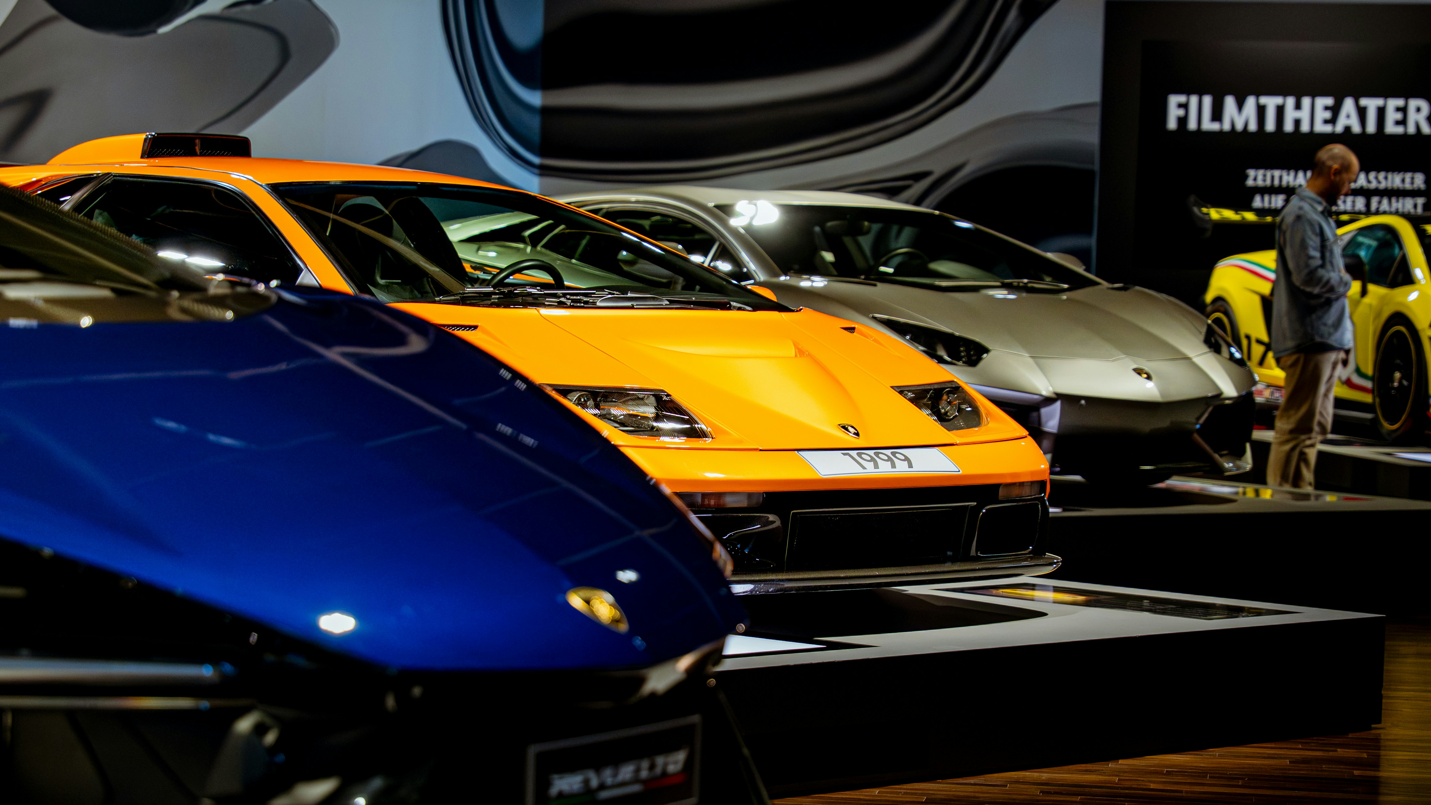 Lustrous Parade: Neon Orange Porsche Leads a Row of Exotic Sports Cars