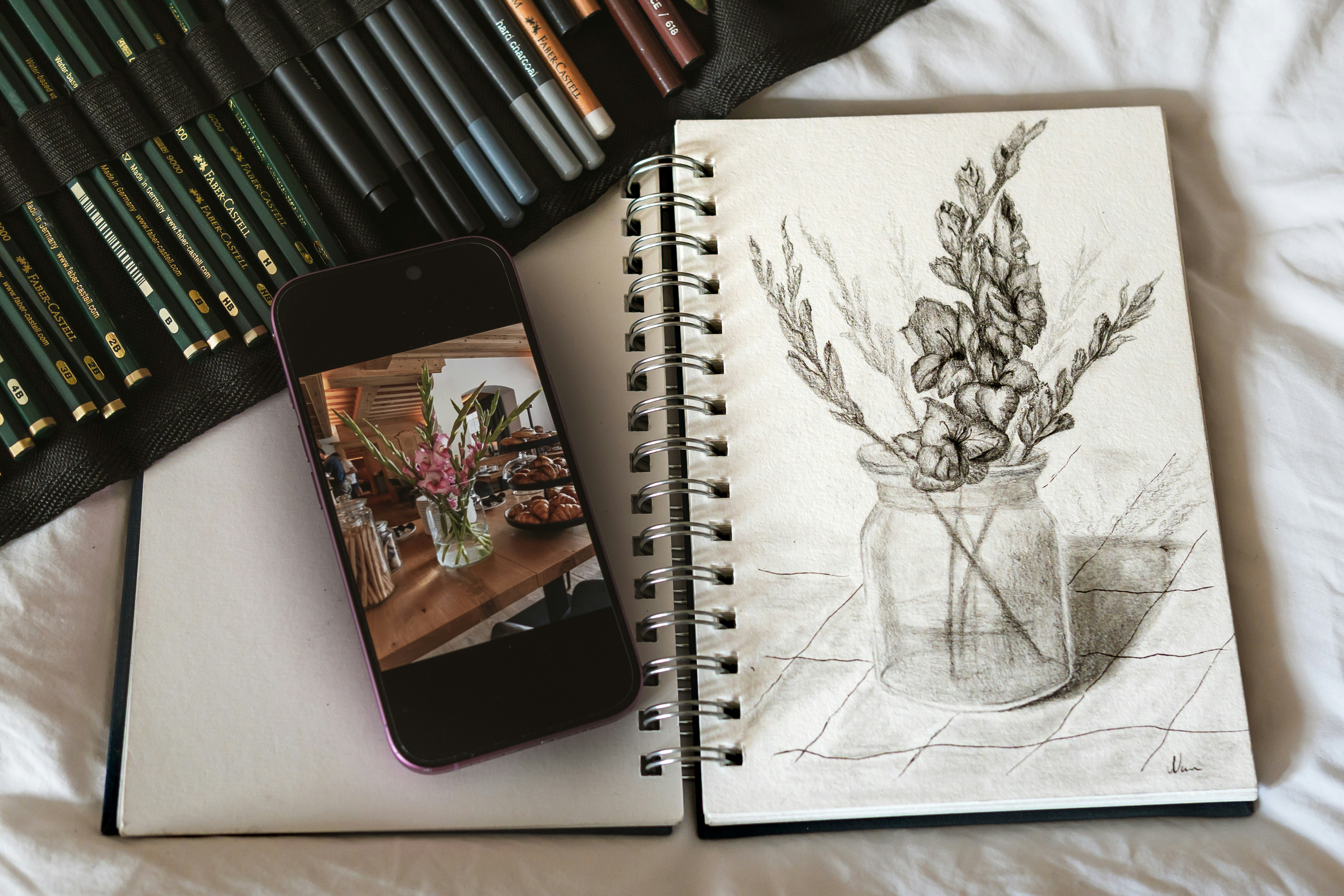 Sketches and Still Life: A Mobile Frame Over a Desk Notebook
