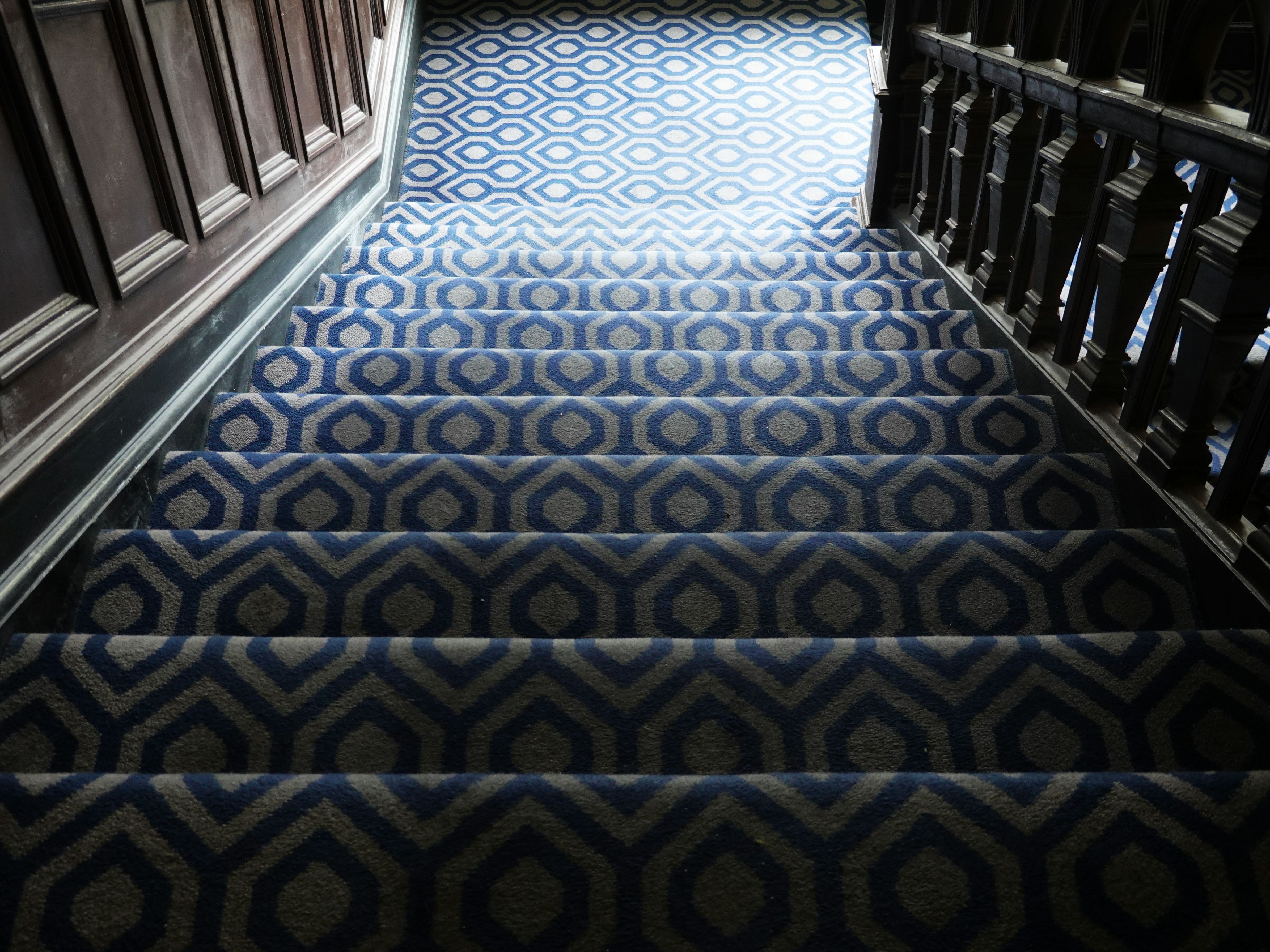 Geometric Carpet Staircase Leading Toward a Bright Landing