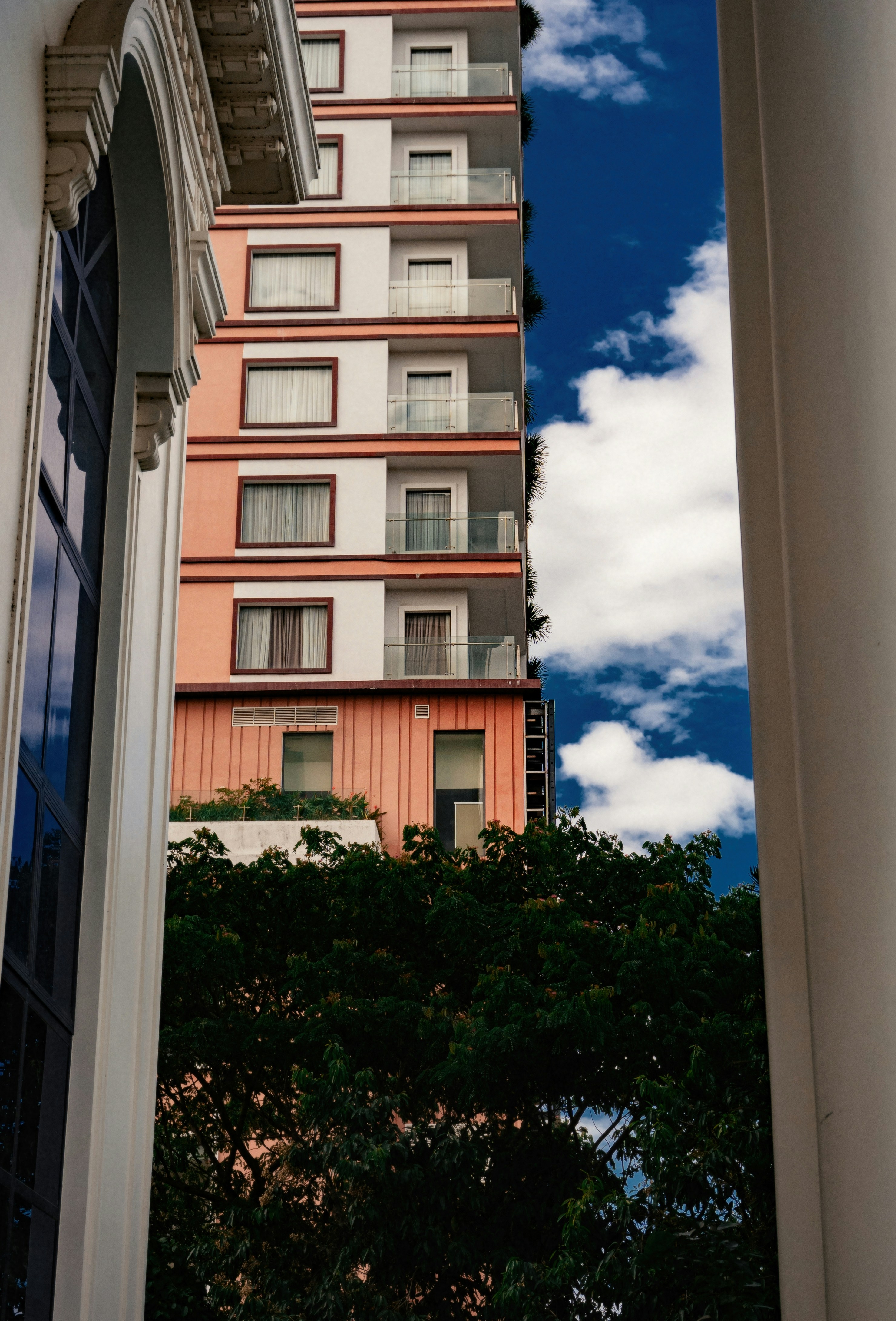 Vertical City: Pink Facade Rising Between Columns