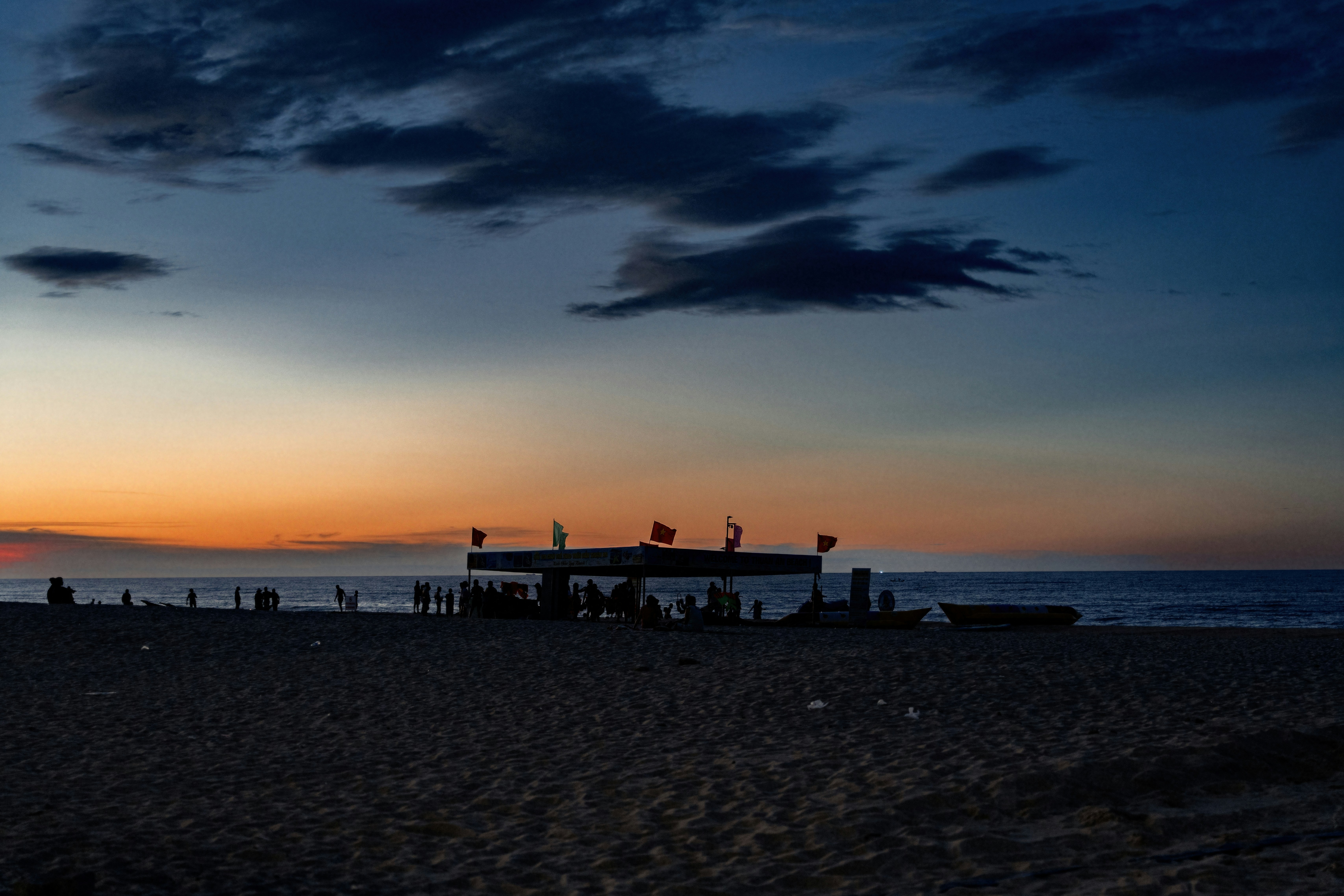 Dusk Departure: Flags and Silhouettes at the Quiet Shore