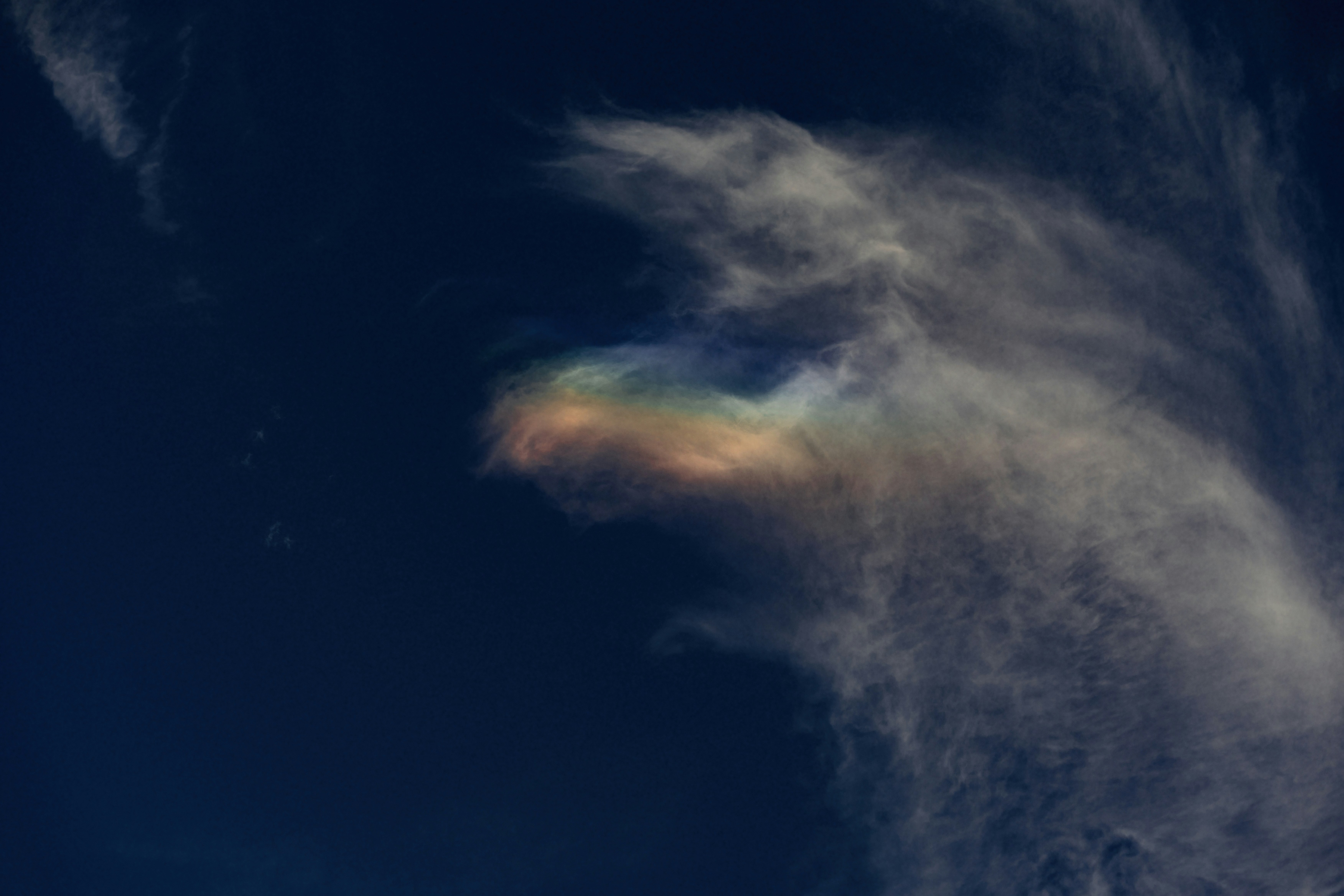 Rainbow-tinted Cloud Slice in a Deep Blue Sky