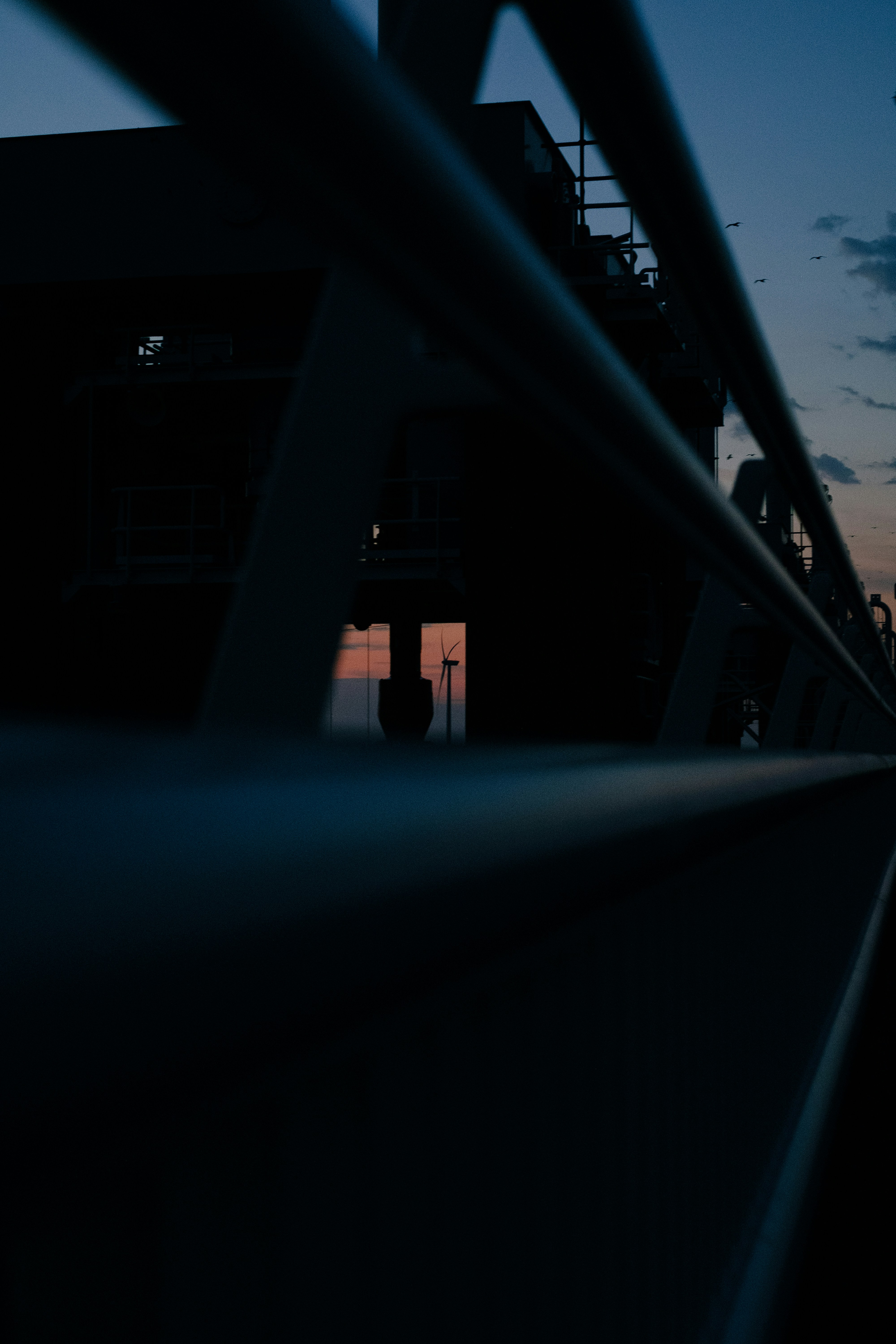 Silhouetted Structure Framed by Sunset Rails