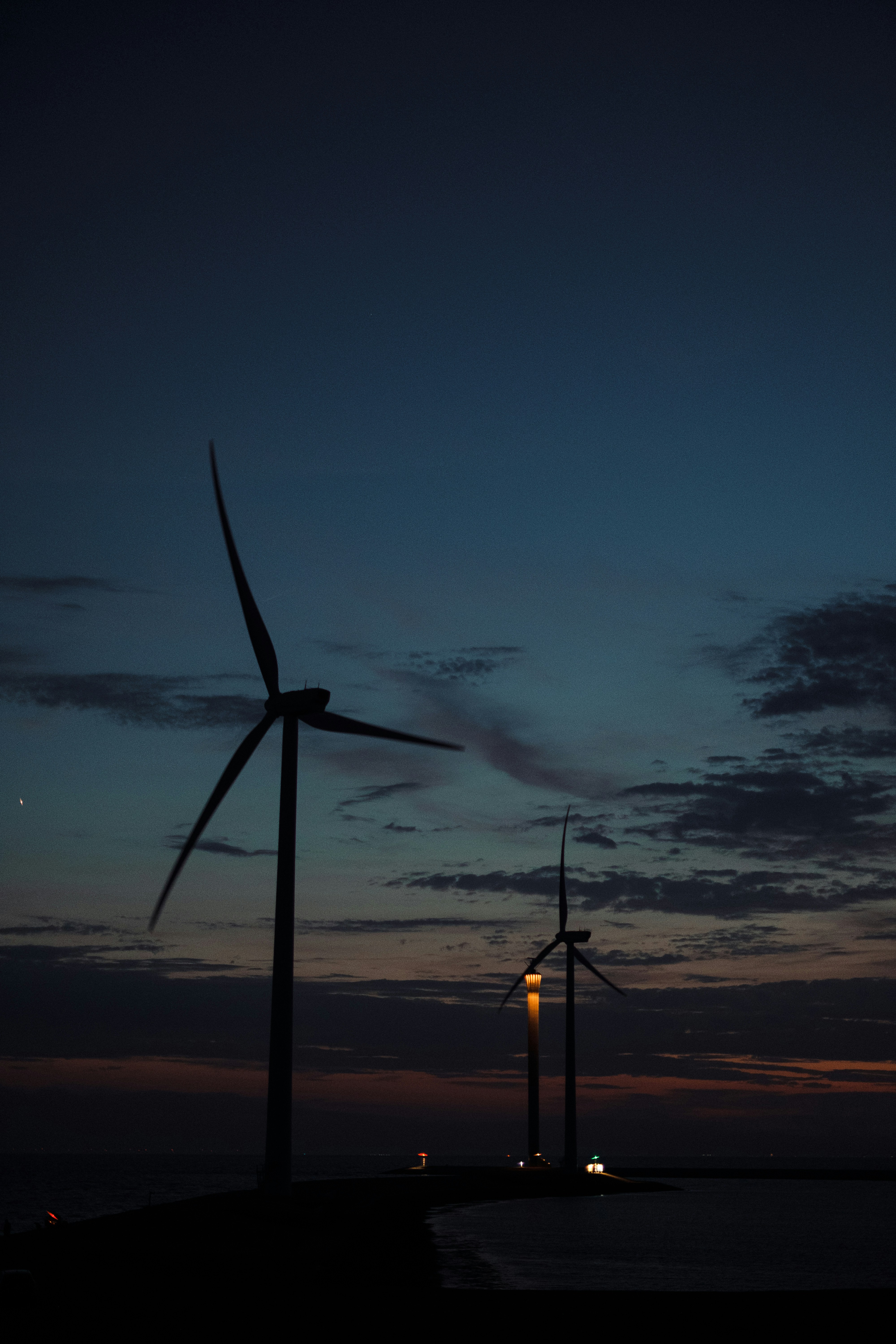 Silhouetted Wind Turbines at Dusk Over a Quiet Confluence