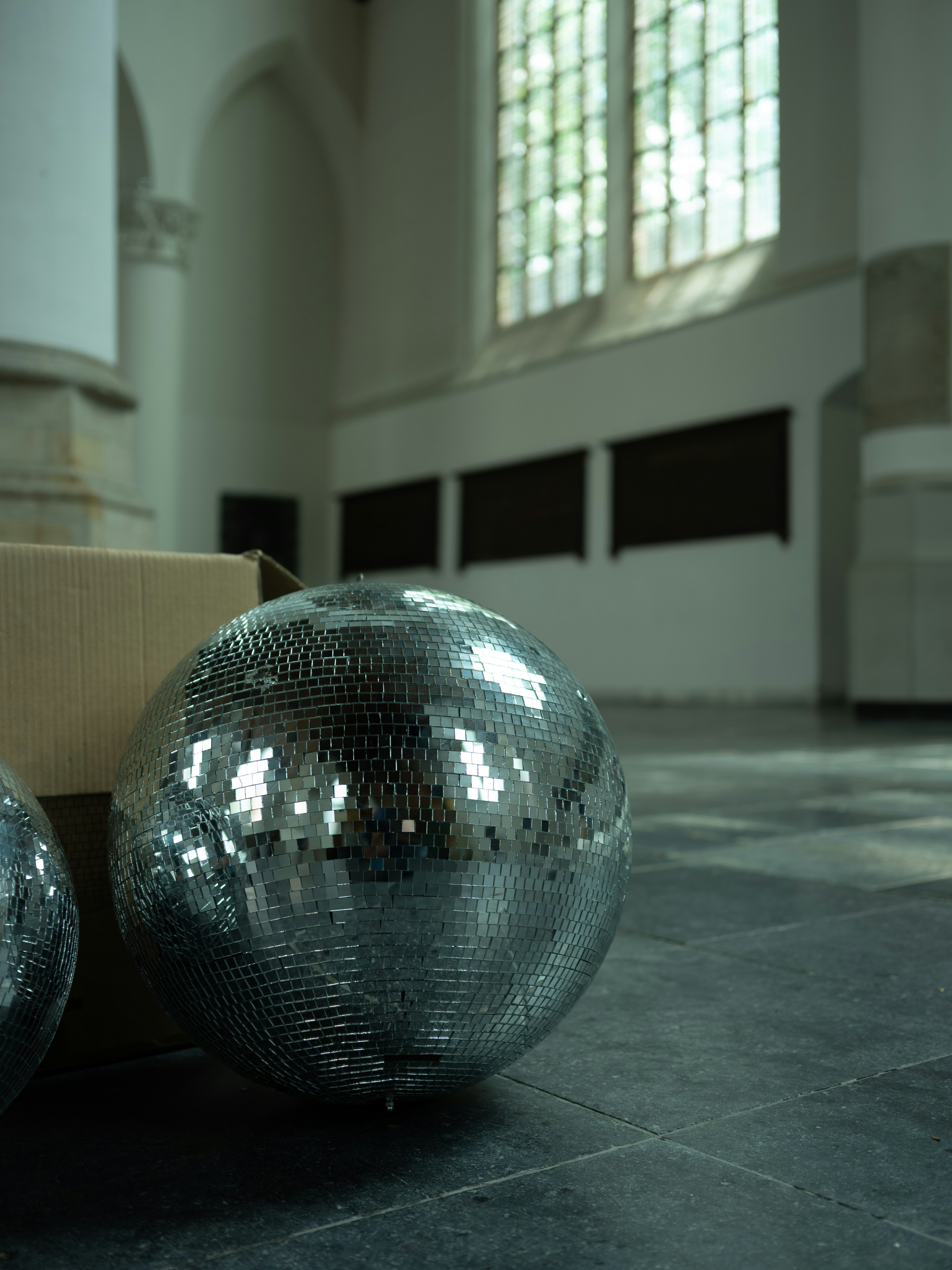 Disco in the Quiet Hall: Mirrored Orbs on a Cement Stage