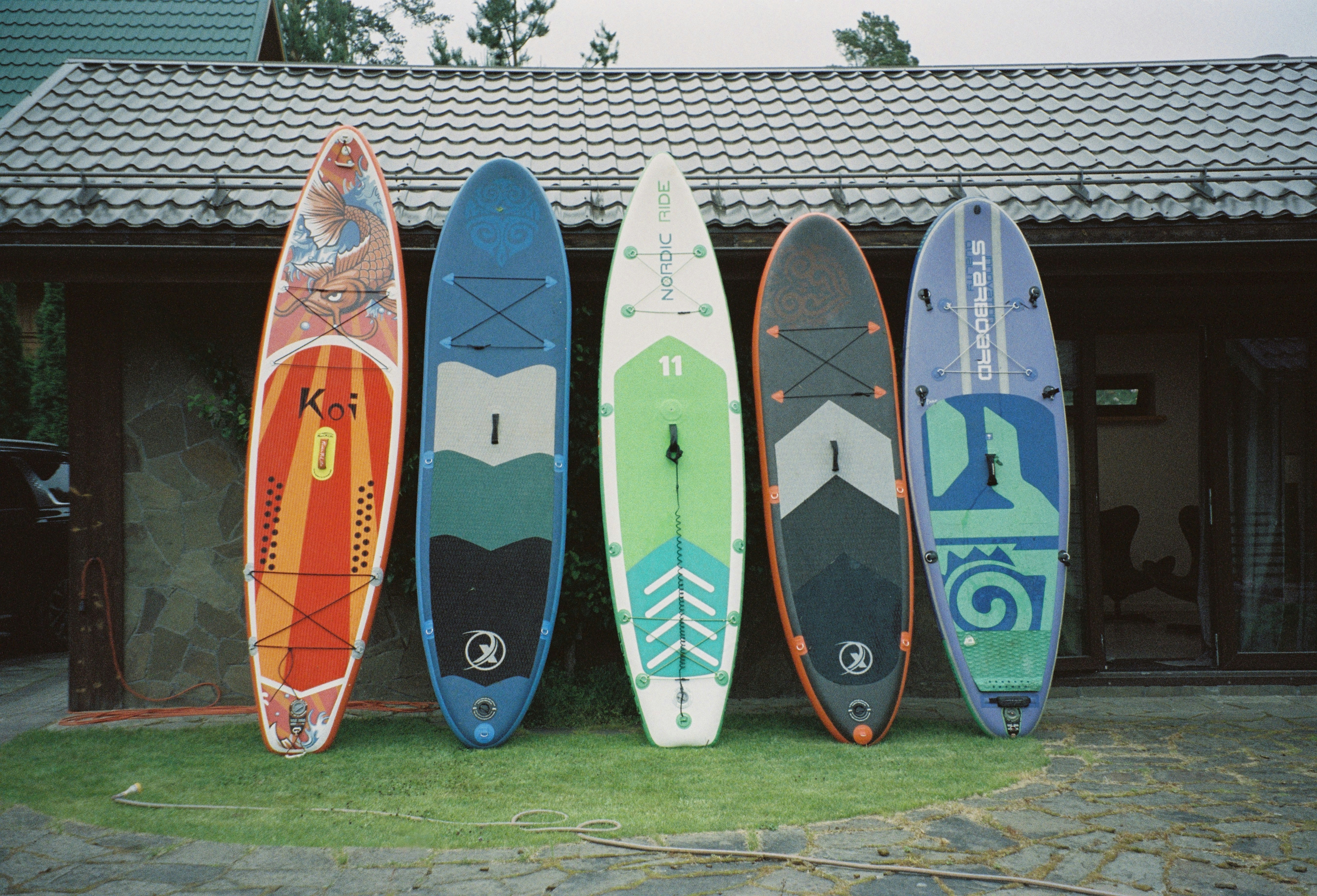 Row of Stand-Up Paddleboards Resting Before a Studio Backdrop