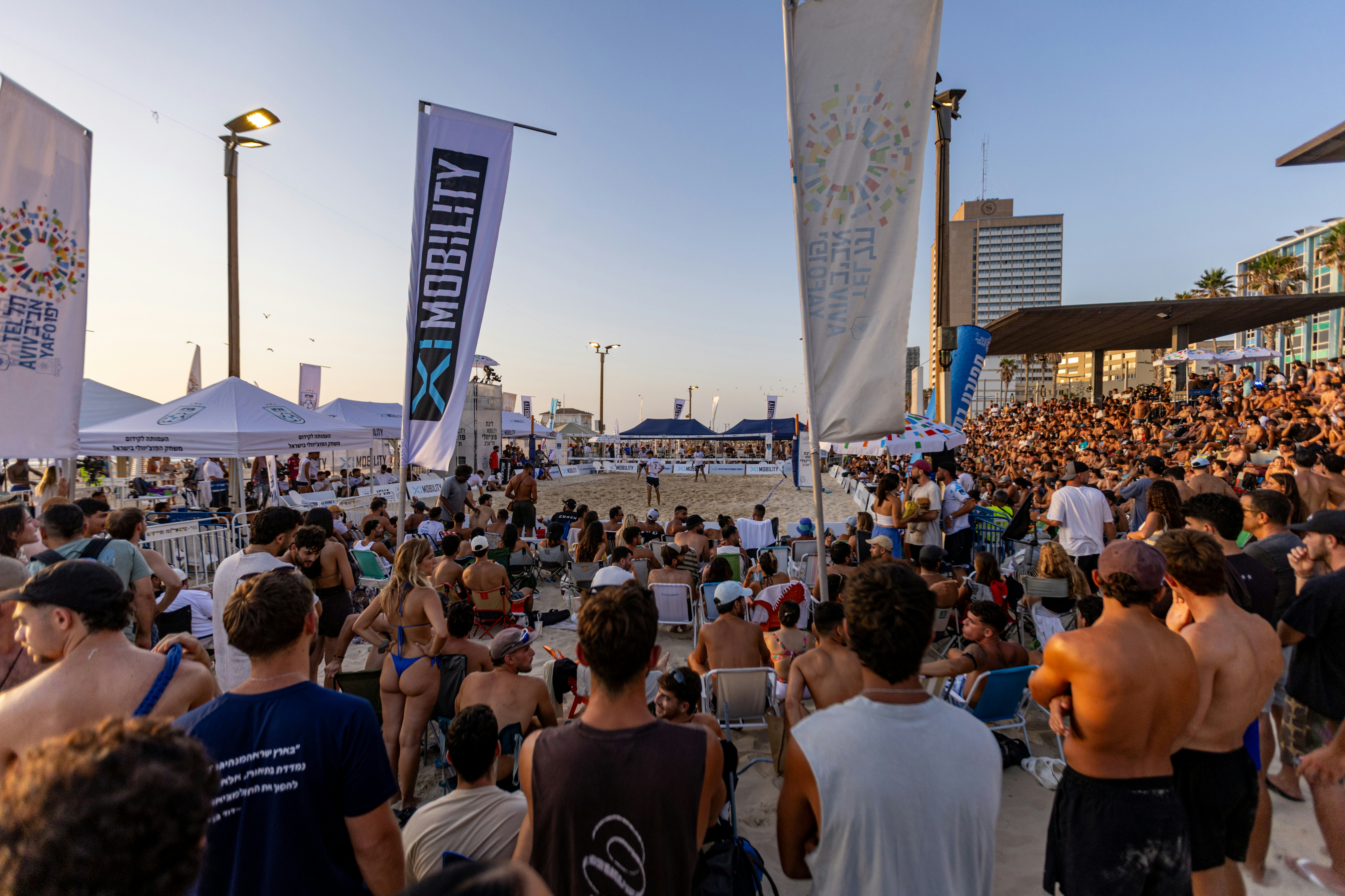 Crowd at the Sunset Arena: Lifeguard Flags and Cityscape