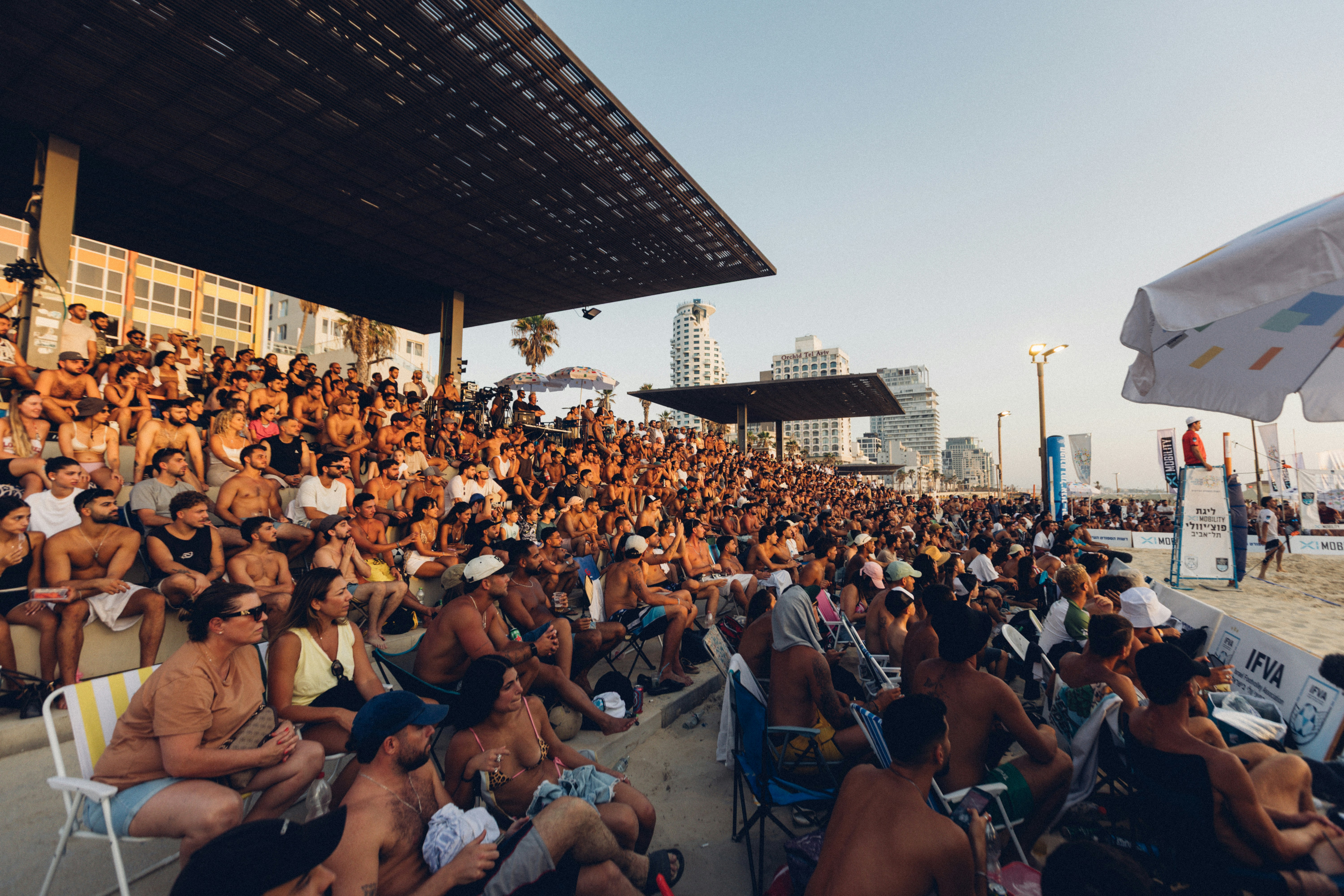 Sunlit Beachside Audience: A Throng at Distant Waves