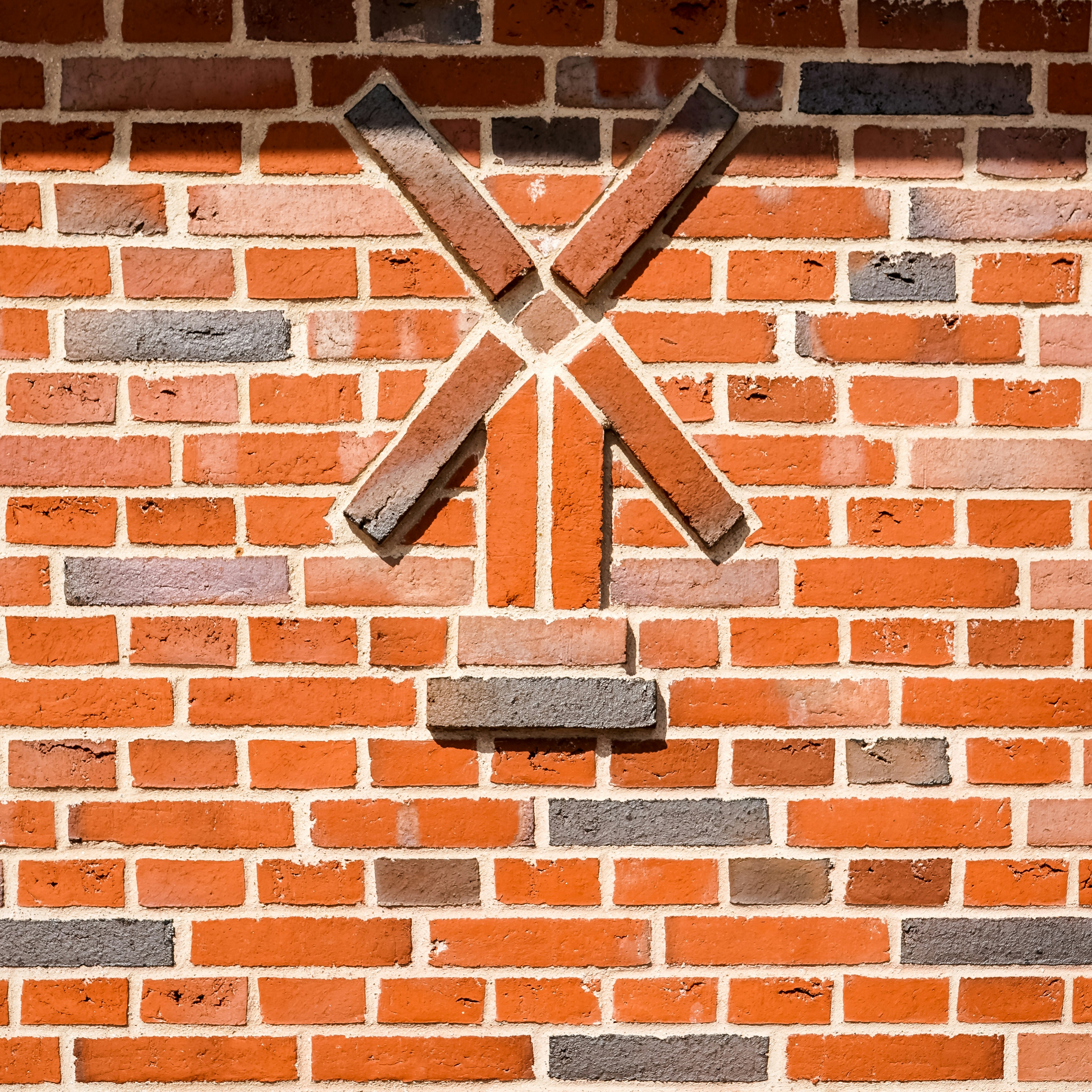 Brick Glyph: The X Mark Emblem on a Weathered Wall