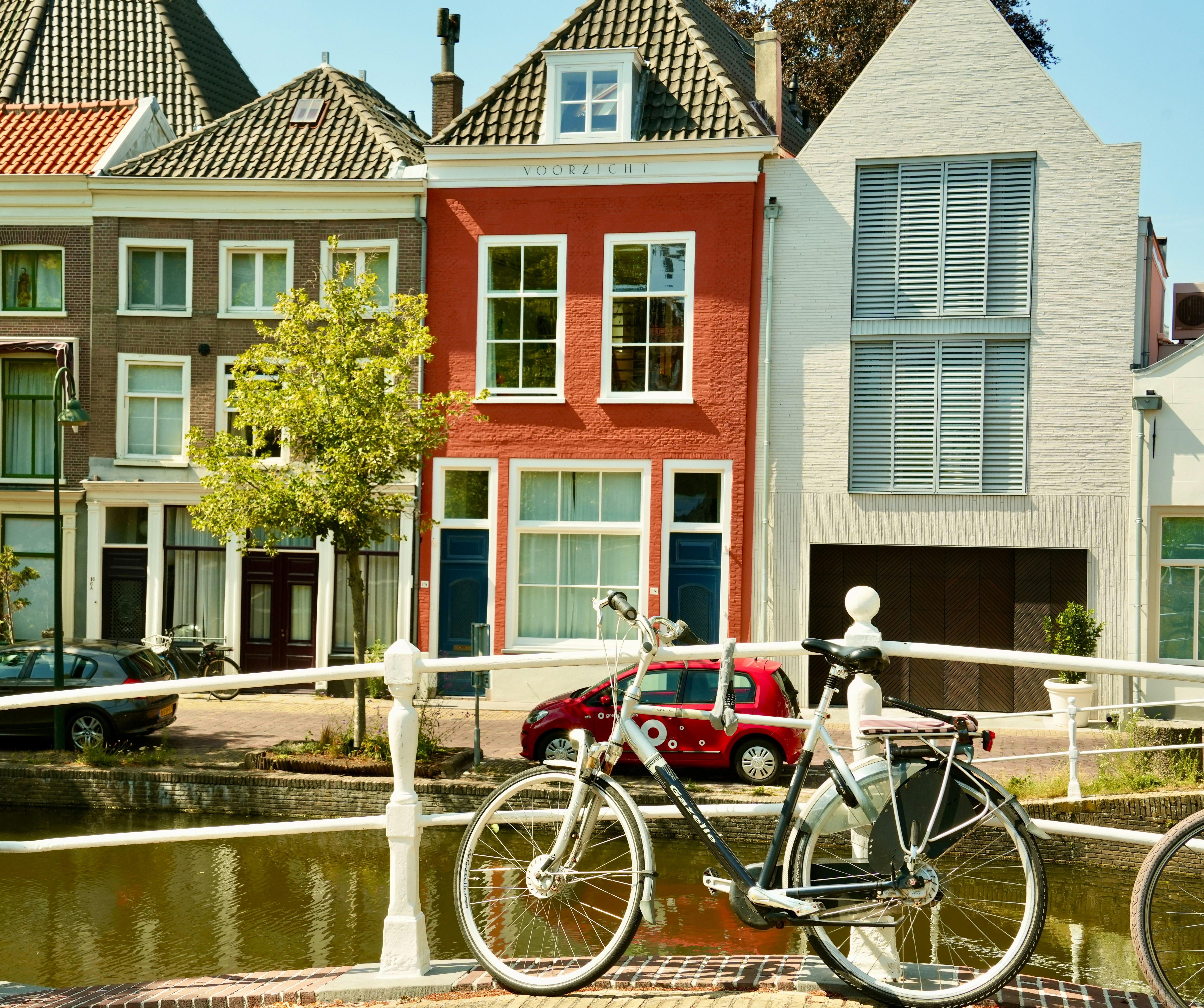 Red-Faced Facade: A Quiet Canalefront with a Resting Bicycle