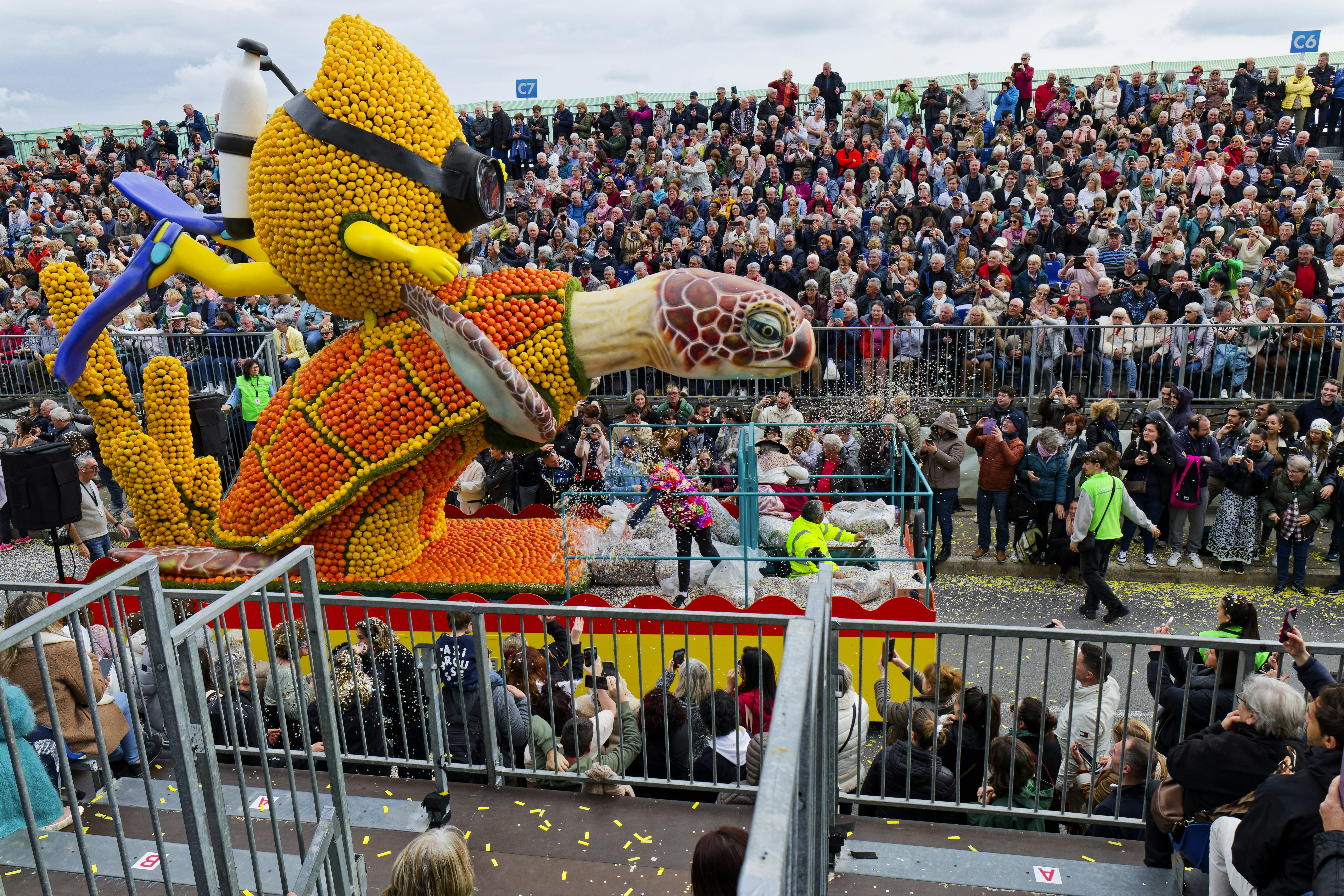 Giant Turtle Parade float roars through a cheering seawall of onlookers