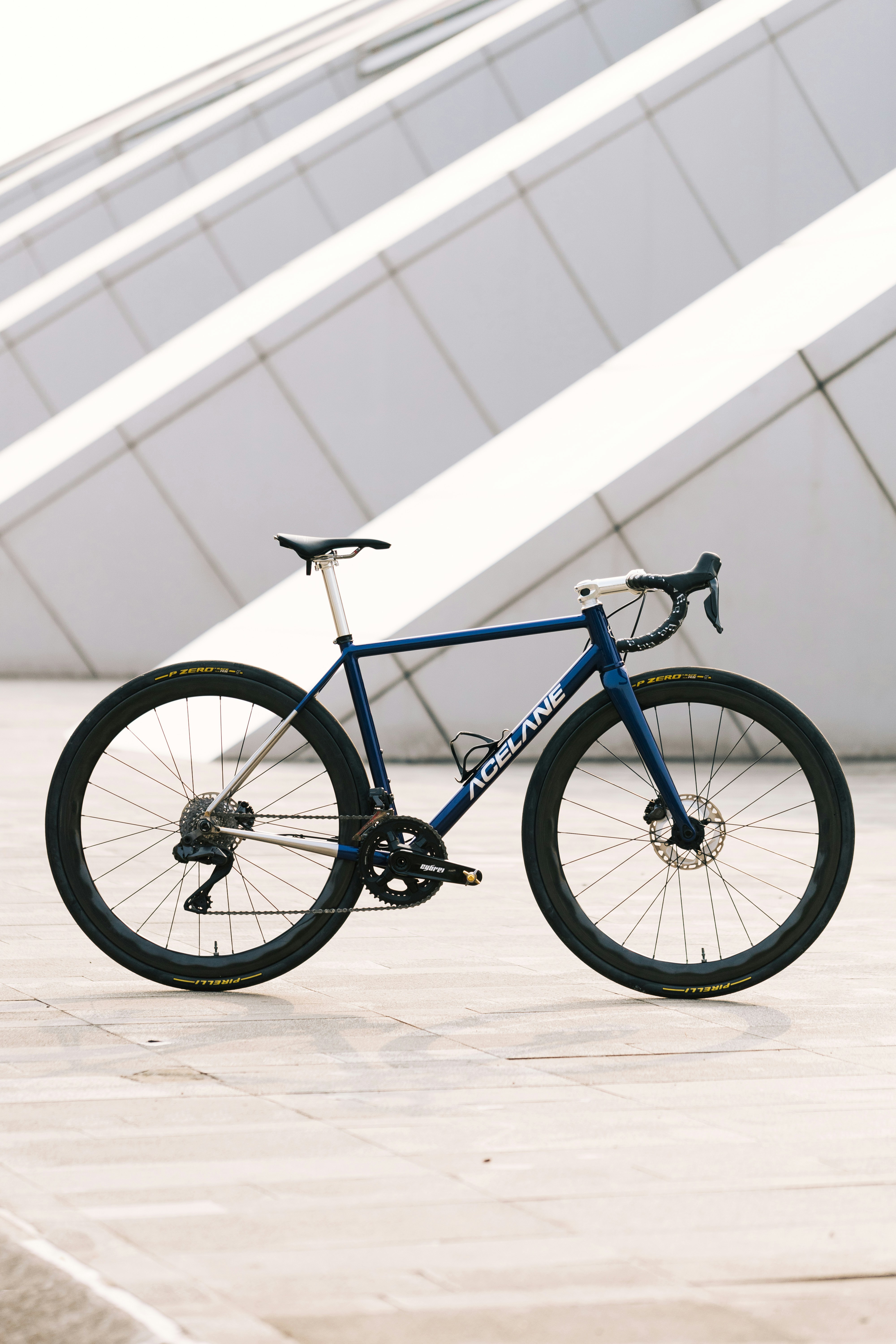 Blue road bike poised on a modern architectural backdrop
