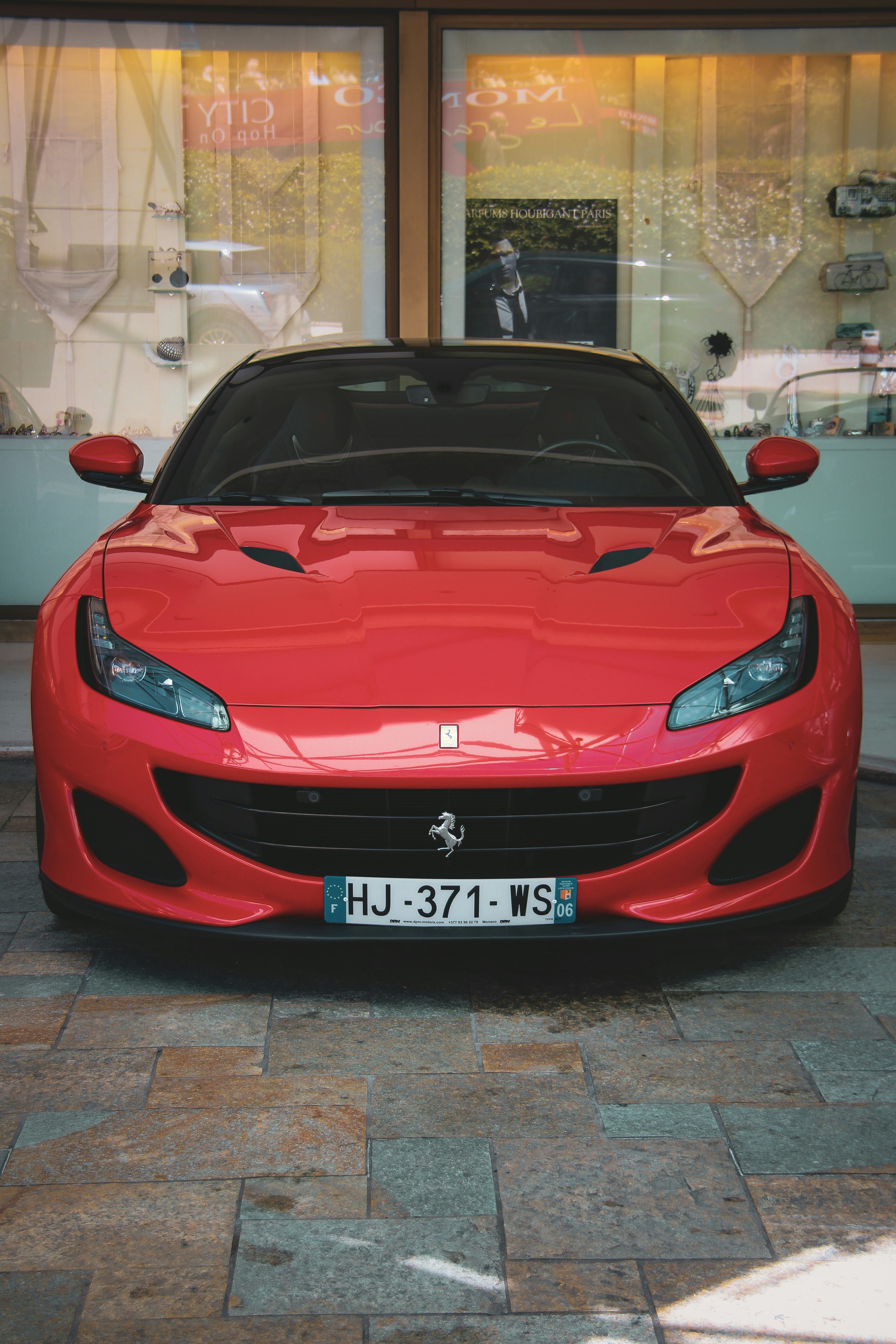 Crimson Stallion: A Front-Focused Portrait of a Ferrari on City Tile
