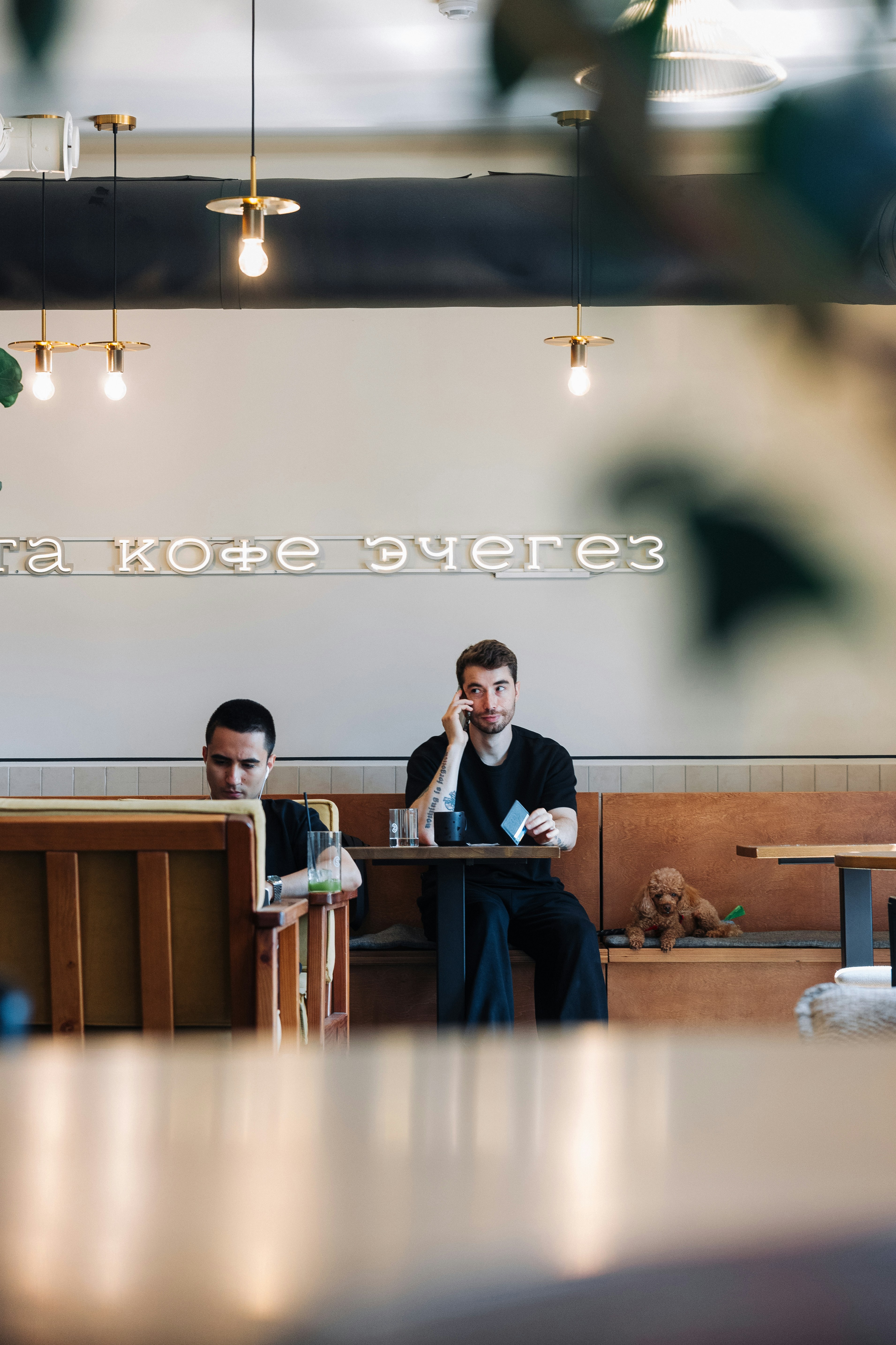Cafe Portrait: Two patrons in a softly lit, modern space