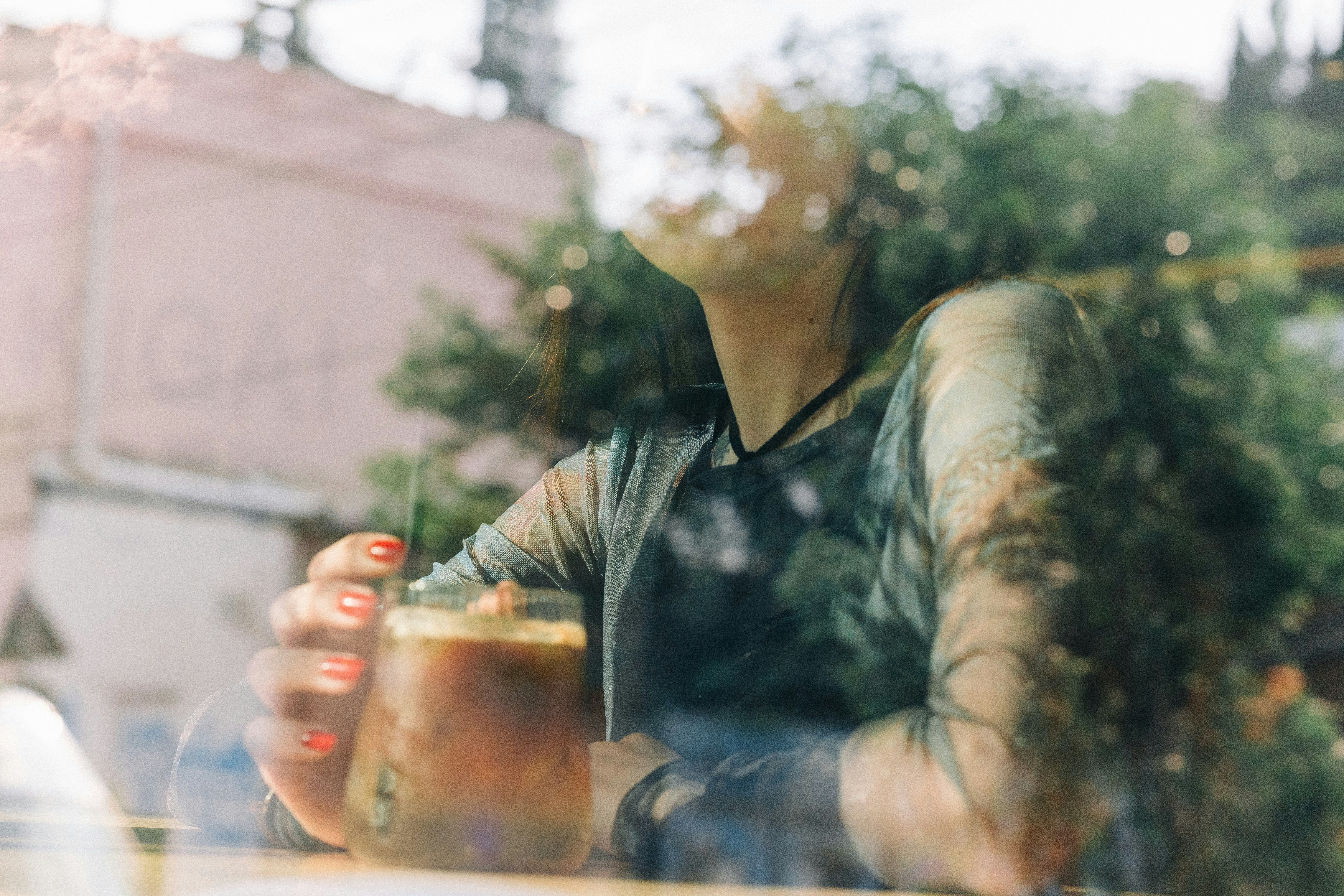Cafe Reflection: A Quiet Moment with a Glass in Focus