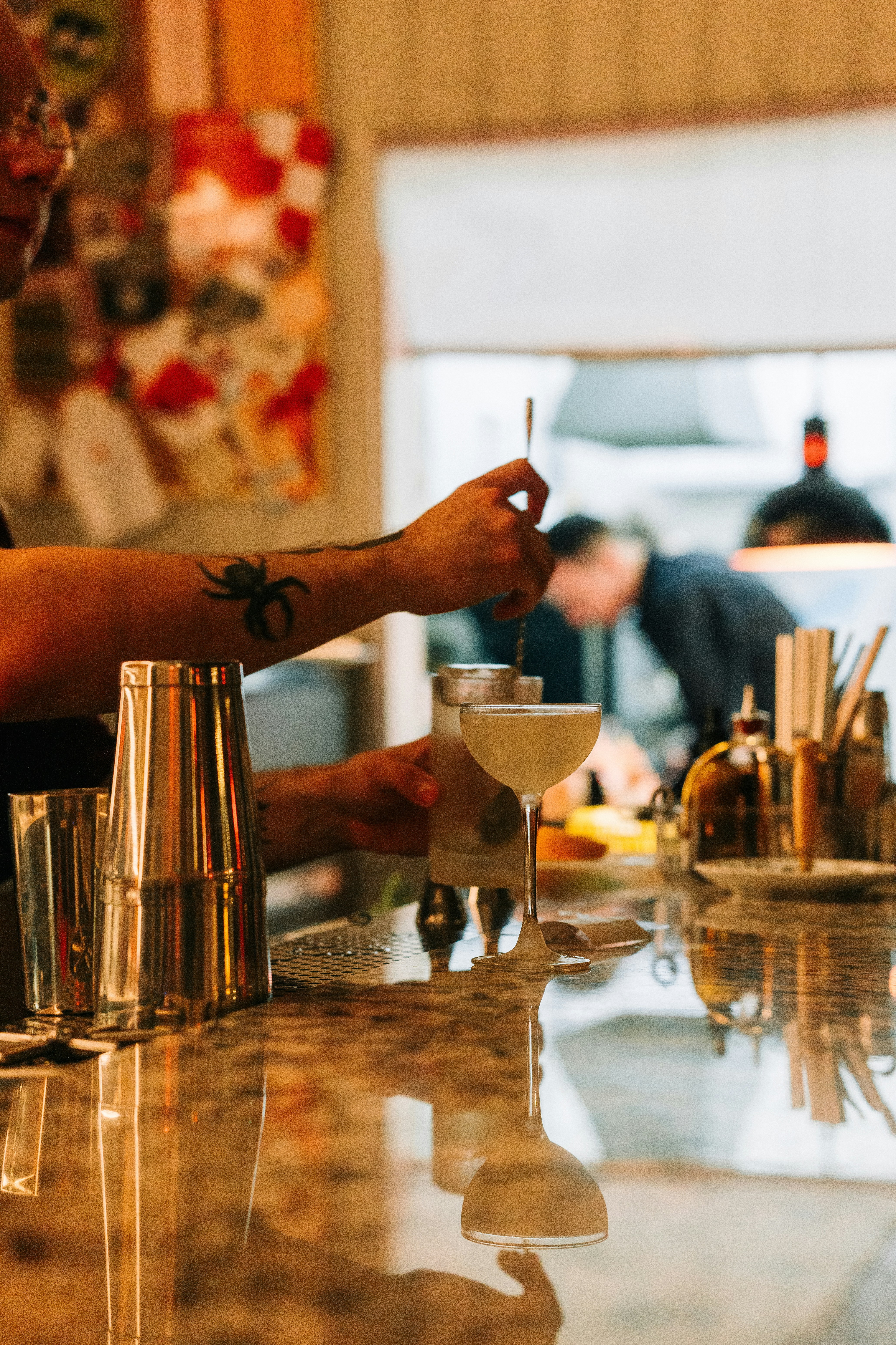 Cocktail Craft: Hand and Glass in a Warm Bar Glow