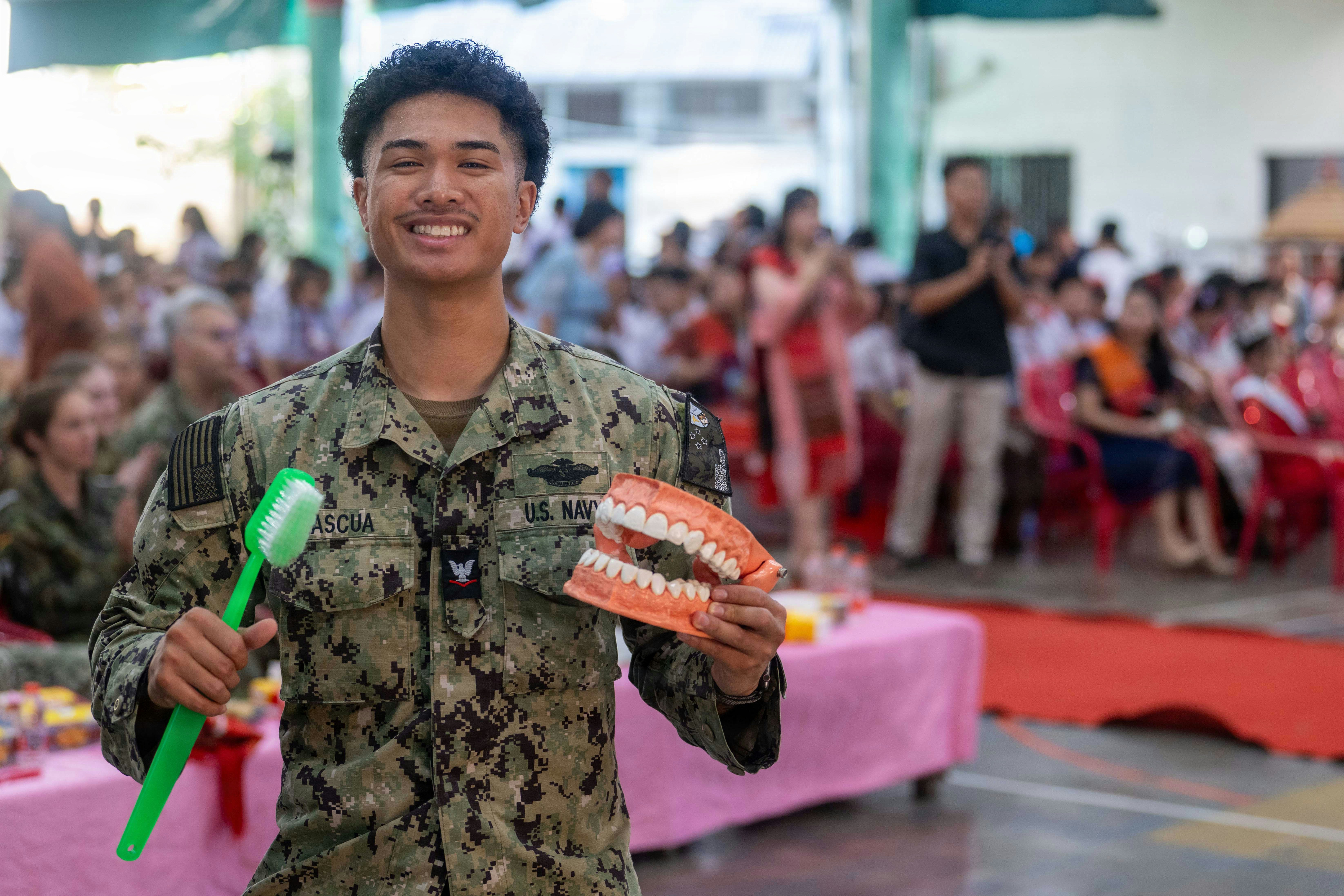 Smile and Show: A Soldier Demonstrates with Dental Props at a Community Event
