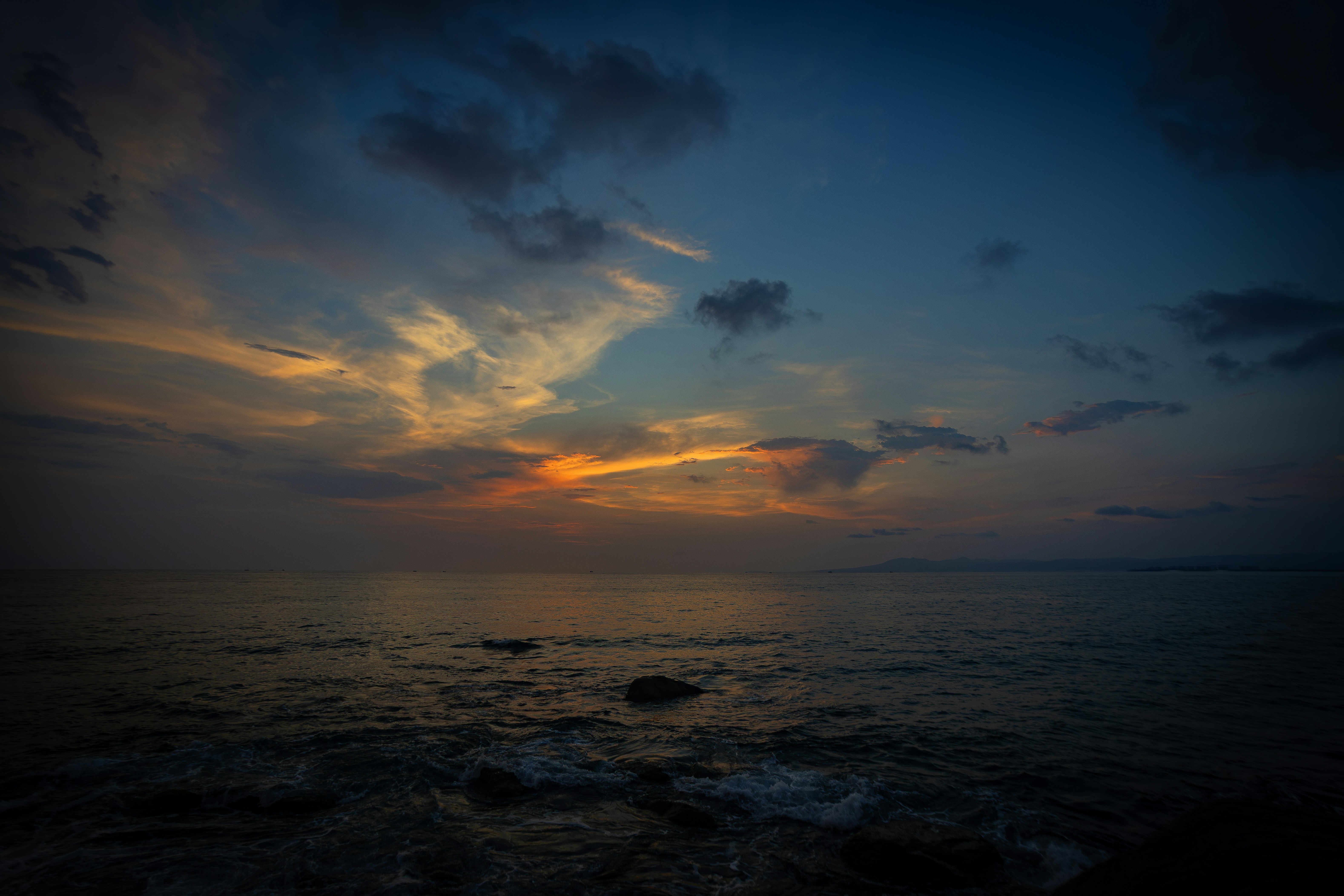Twilight on the Quiet Edge: Sunlit Strata Over a Dark Sea