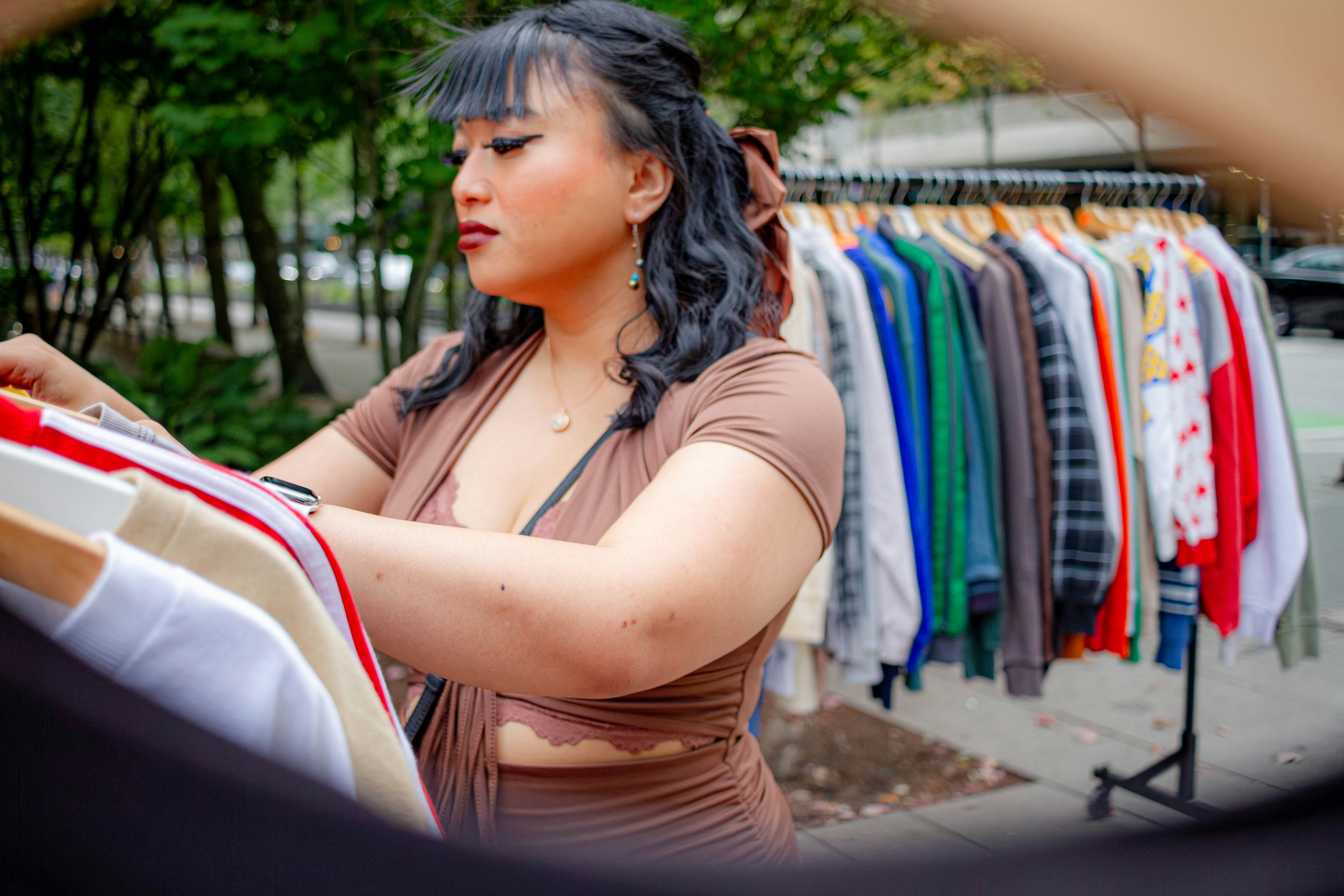 Boutique Stall, Focused Pose: A Seller Sifts Through Fabrics