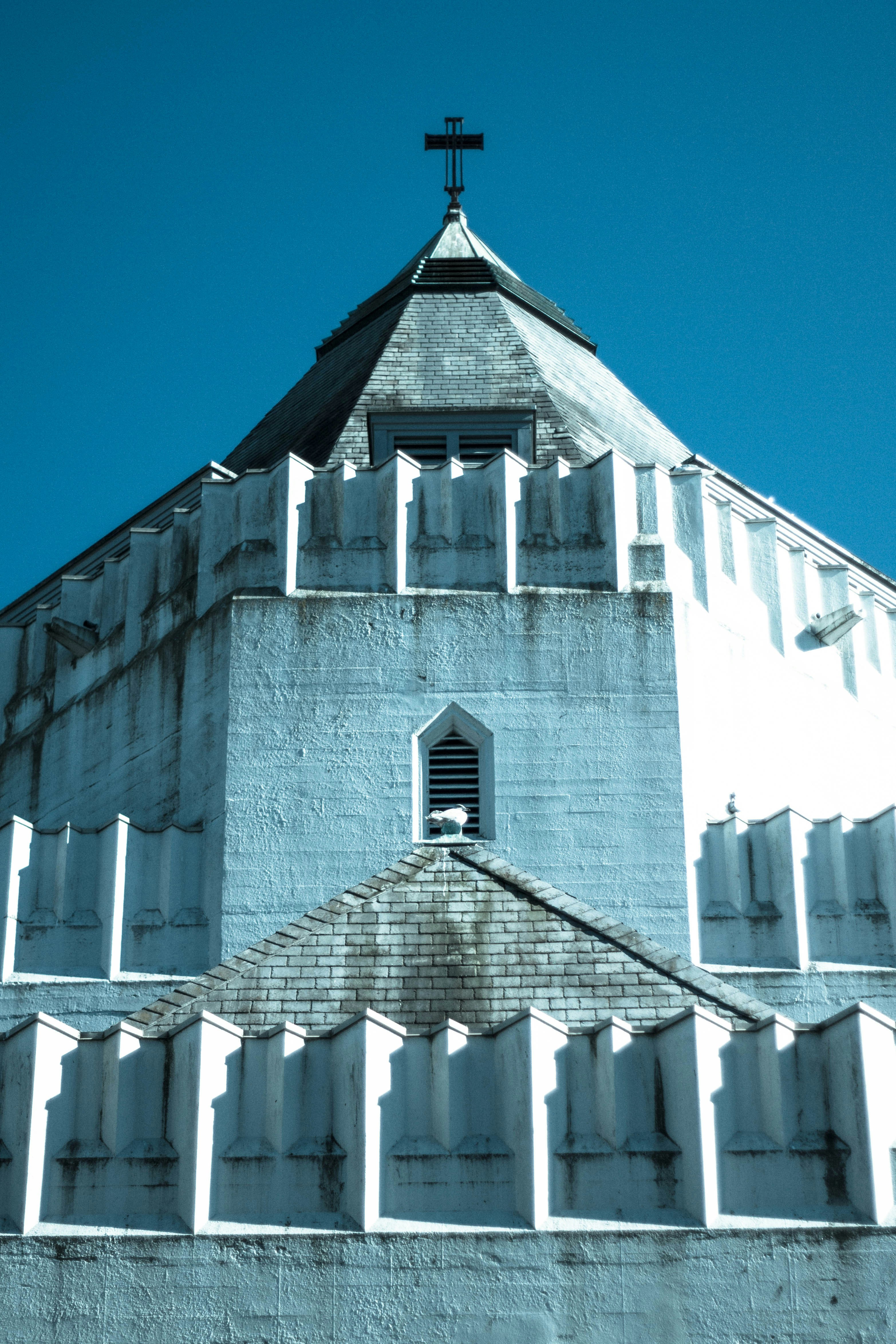 Cross at the Peak: Architectural Symmetry of a White Chapel Roof